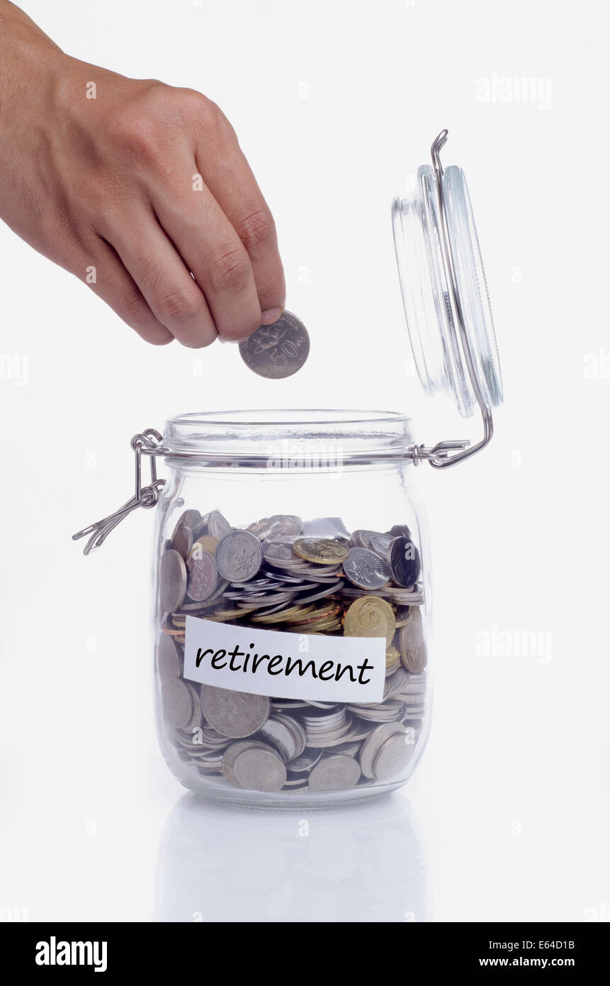 Hand putting a coin into glass jars with 'retirement' text Stock Photo ...