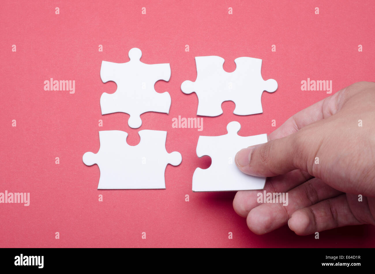 Hand arranging white puzzle Stock Photo - Alamy