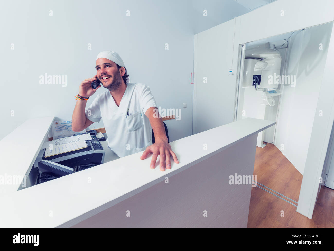 Dentist in reception area speaking on the phone Stock Photo - Alamy