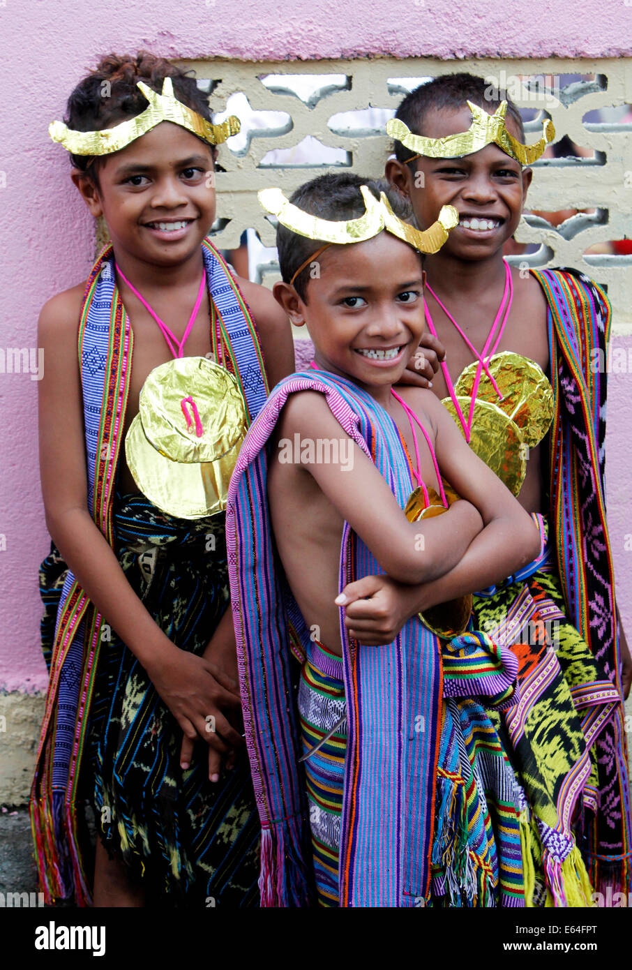 Children in traditional clothes and golden paper headdresses and medals ...