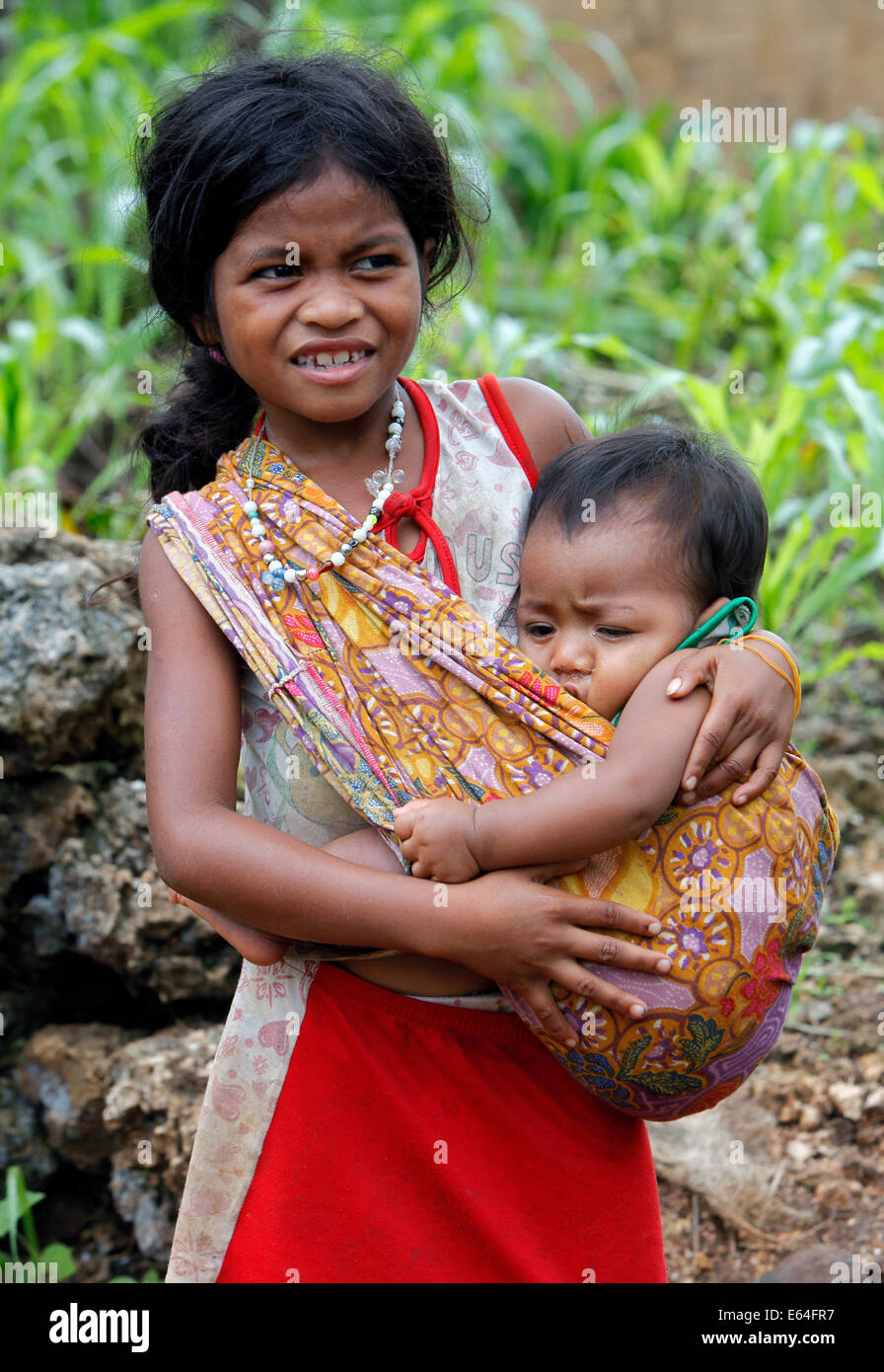 Young girl carry her baby sister in a sling . Timor Leste, East Timor ...