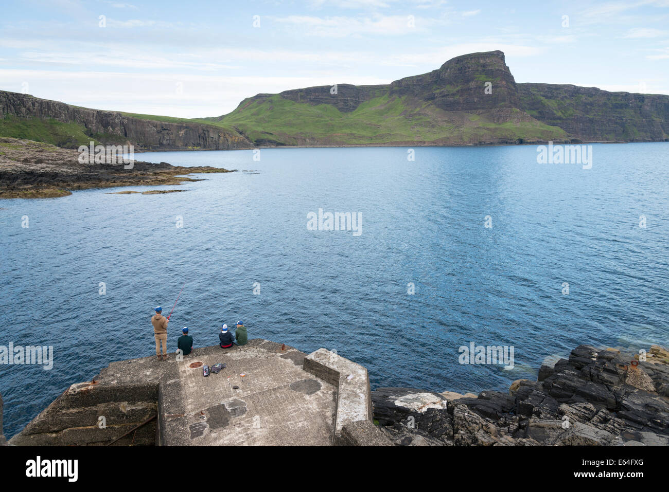 Four young people fishing off the coast of Neist Point Isle of Skye ...