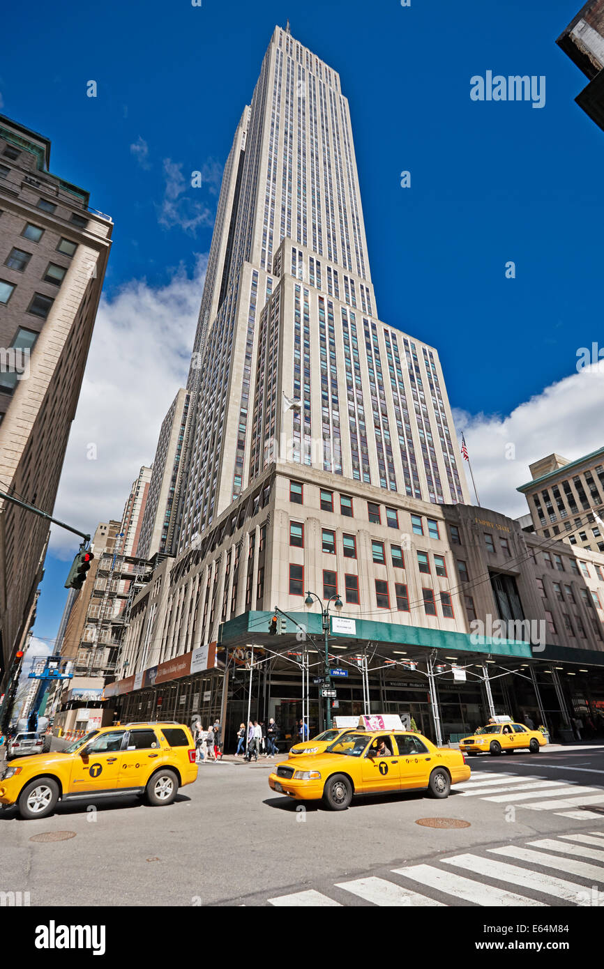 Yellow Medallion taxi cabs passing by the Empire State Building, New ...