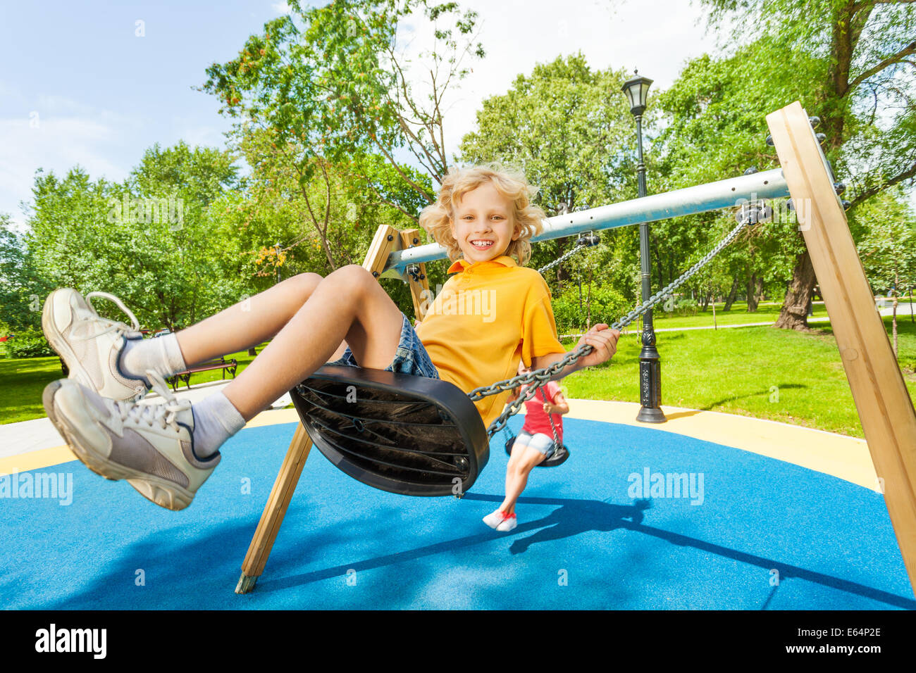 Boy swings in opposite direction to the girl Stock Photo - Alamy
