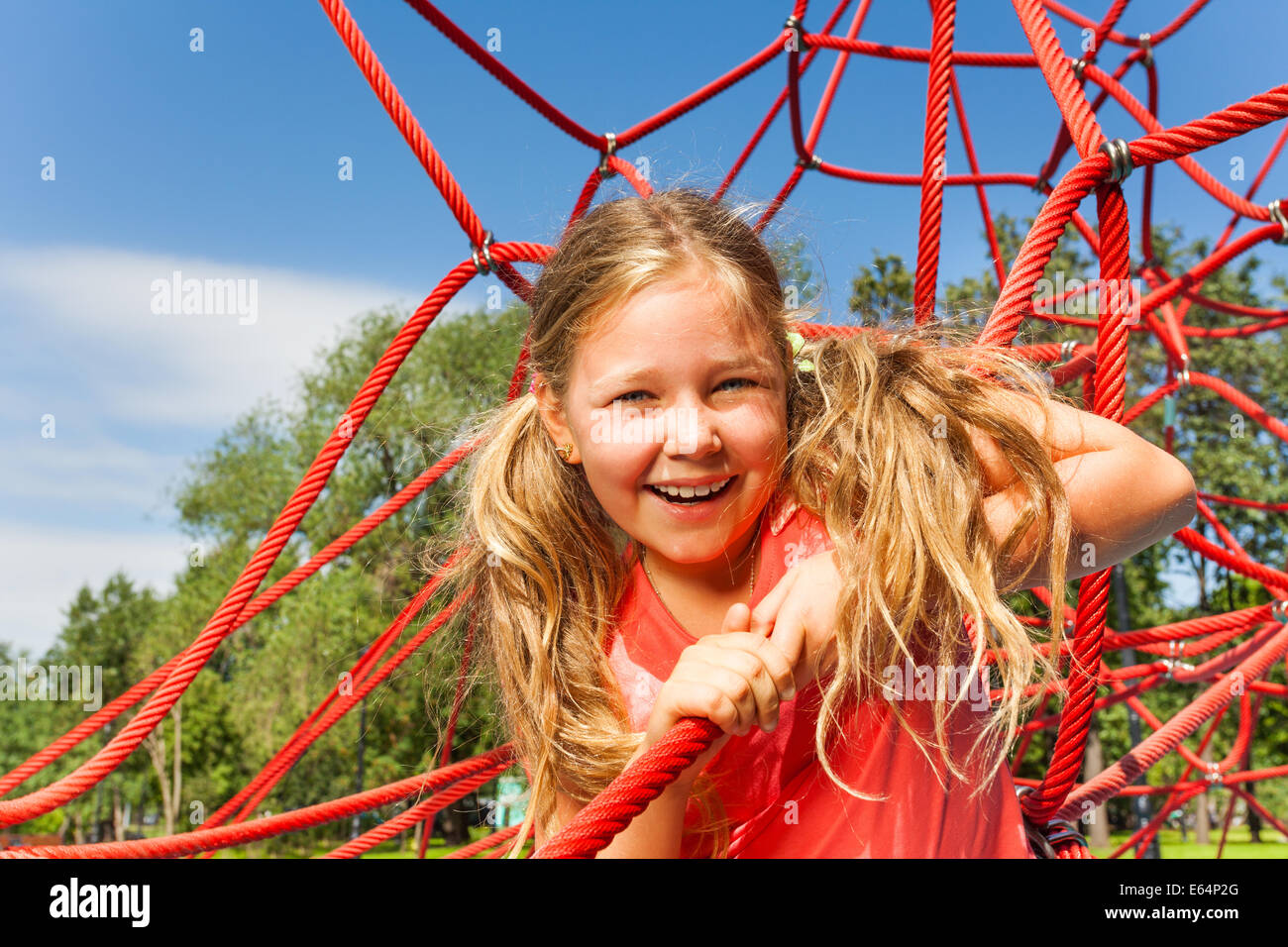 Pretty girl holding rope of red web in summer Stock Photo - Alamy