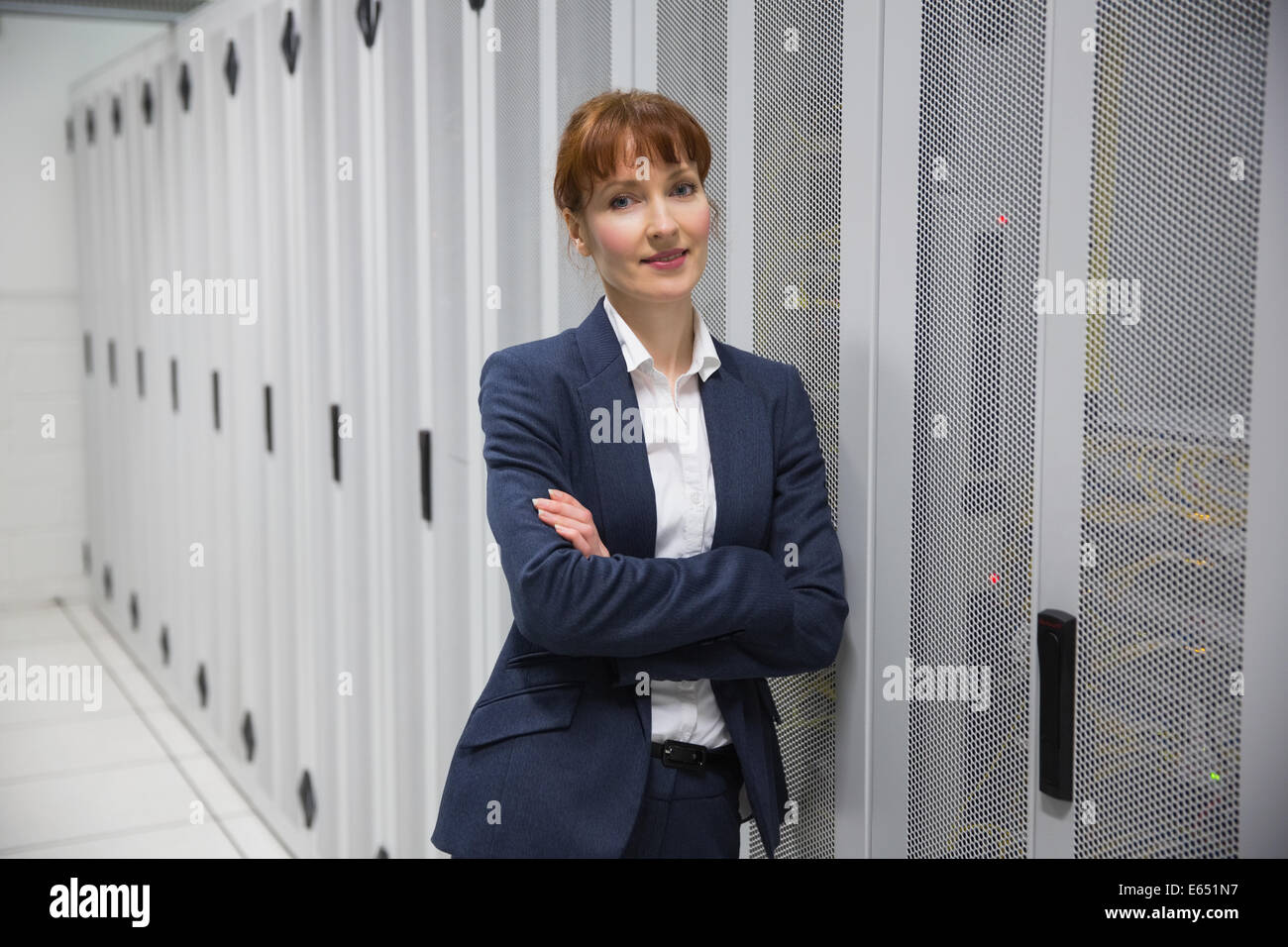 Pretty computer technician looking at camera Stock Photo - Alamy