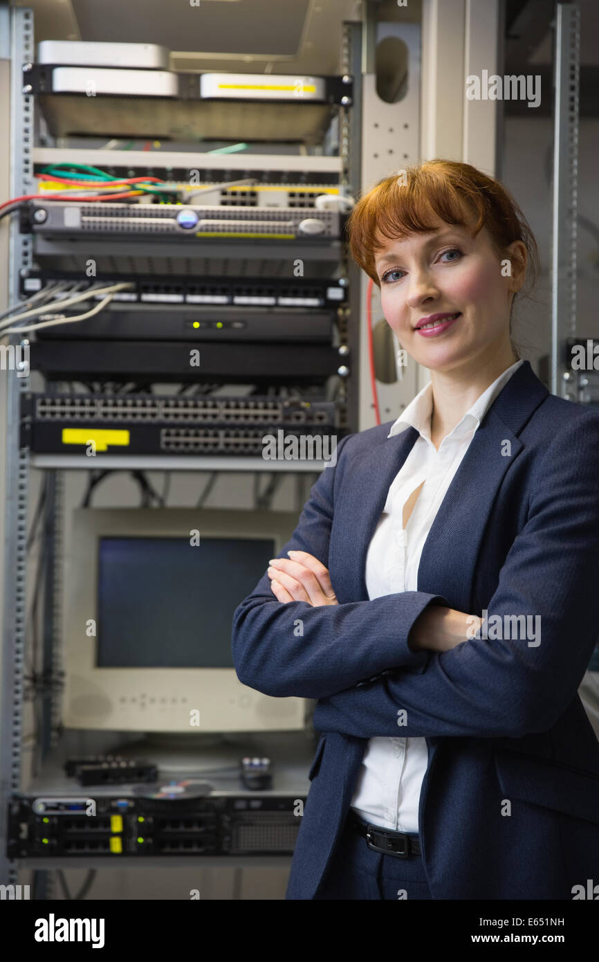 Pretty computer technician smiling at camera beside server Stock Photo ...