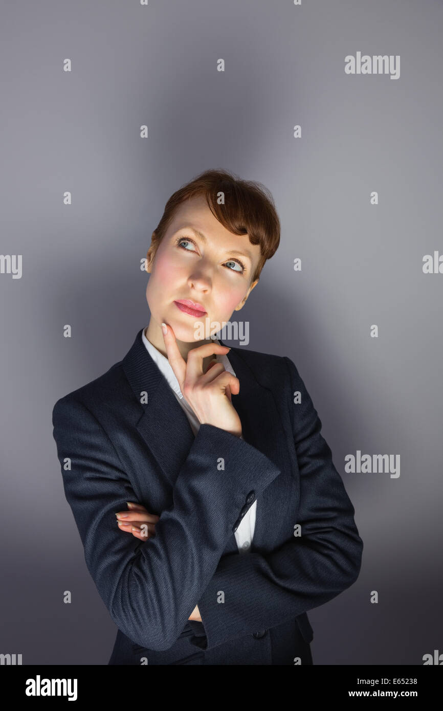 Businesswoman in suit thinking with finger on chin Stock Photo - Alamy