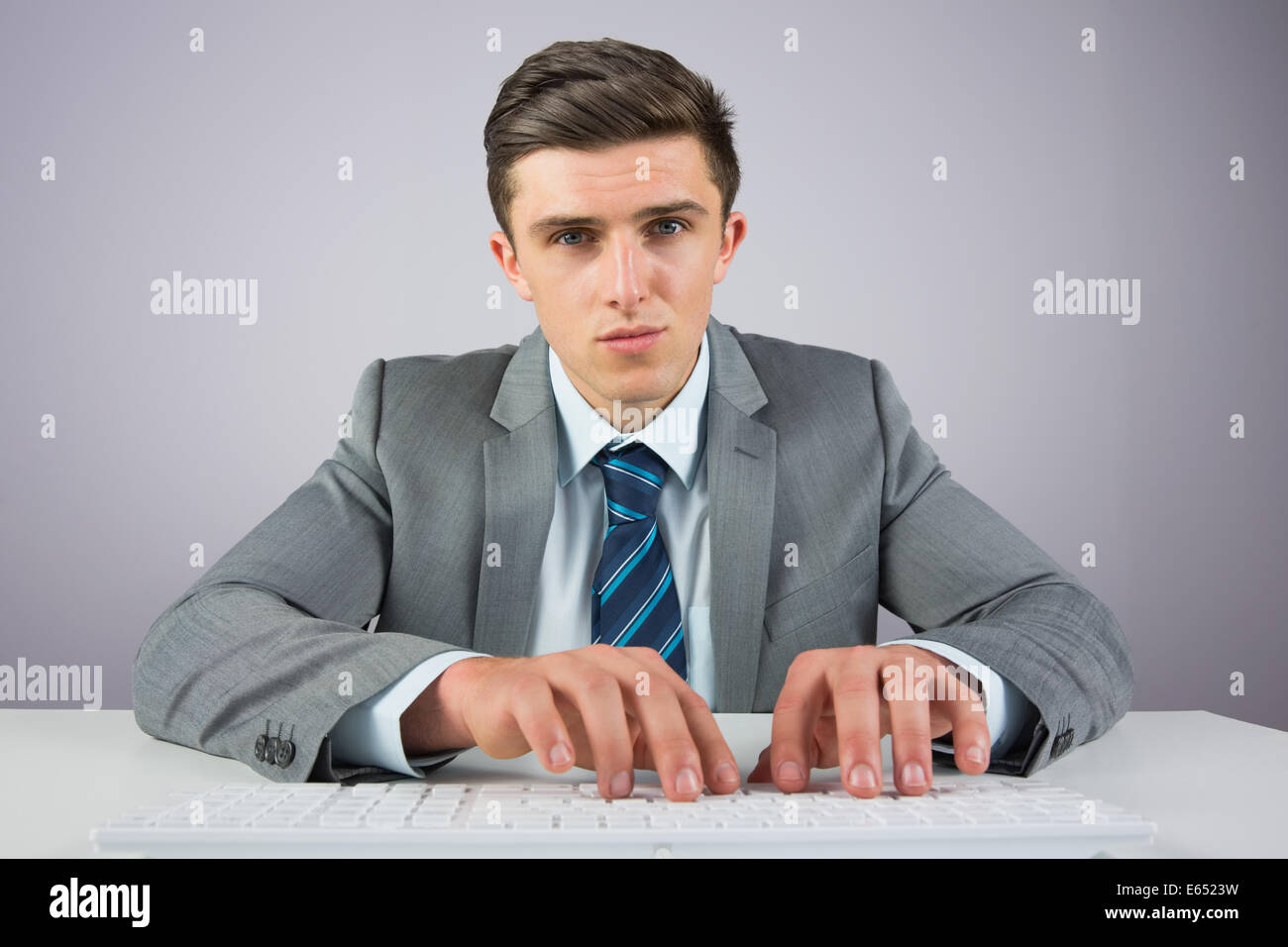 Businessman sitting at desk typing Stock Photo - Alamy