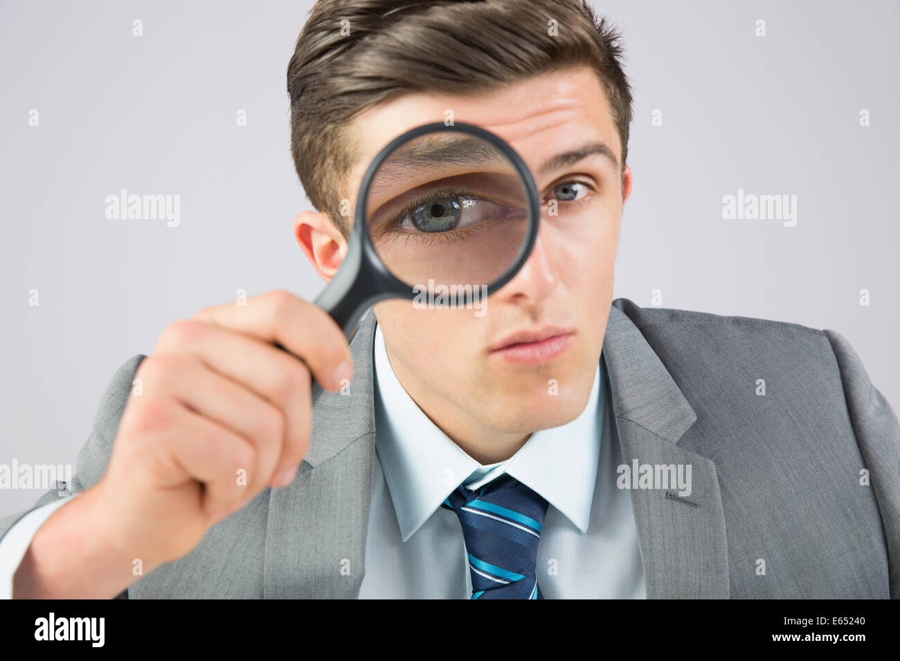 Businessman looking through magnifying glass Stock Photo - Alamy