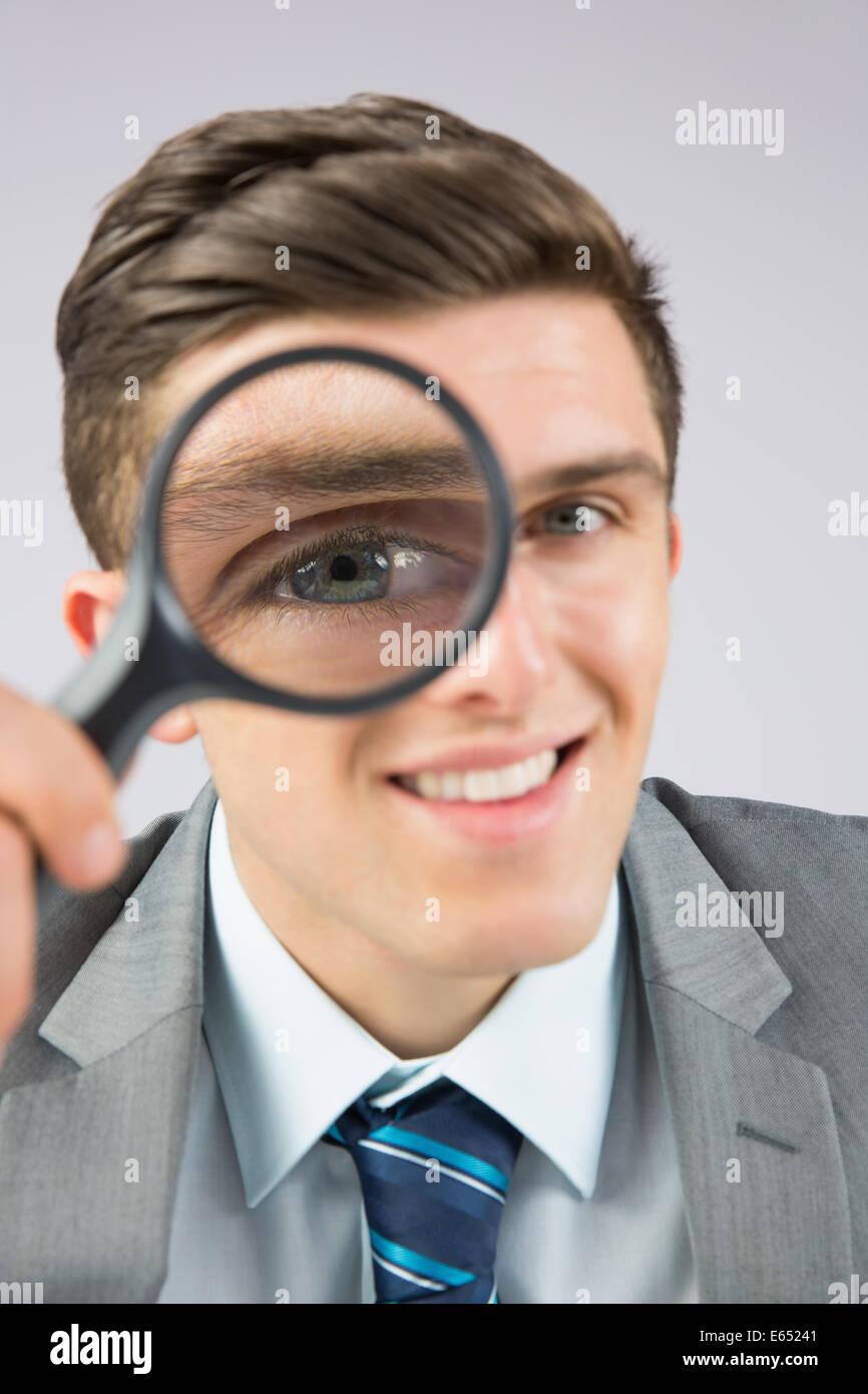 Businessman looking through magnifying glass Stock Photo - Alamy