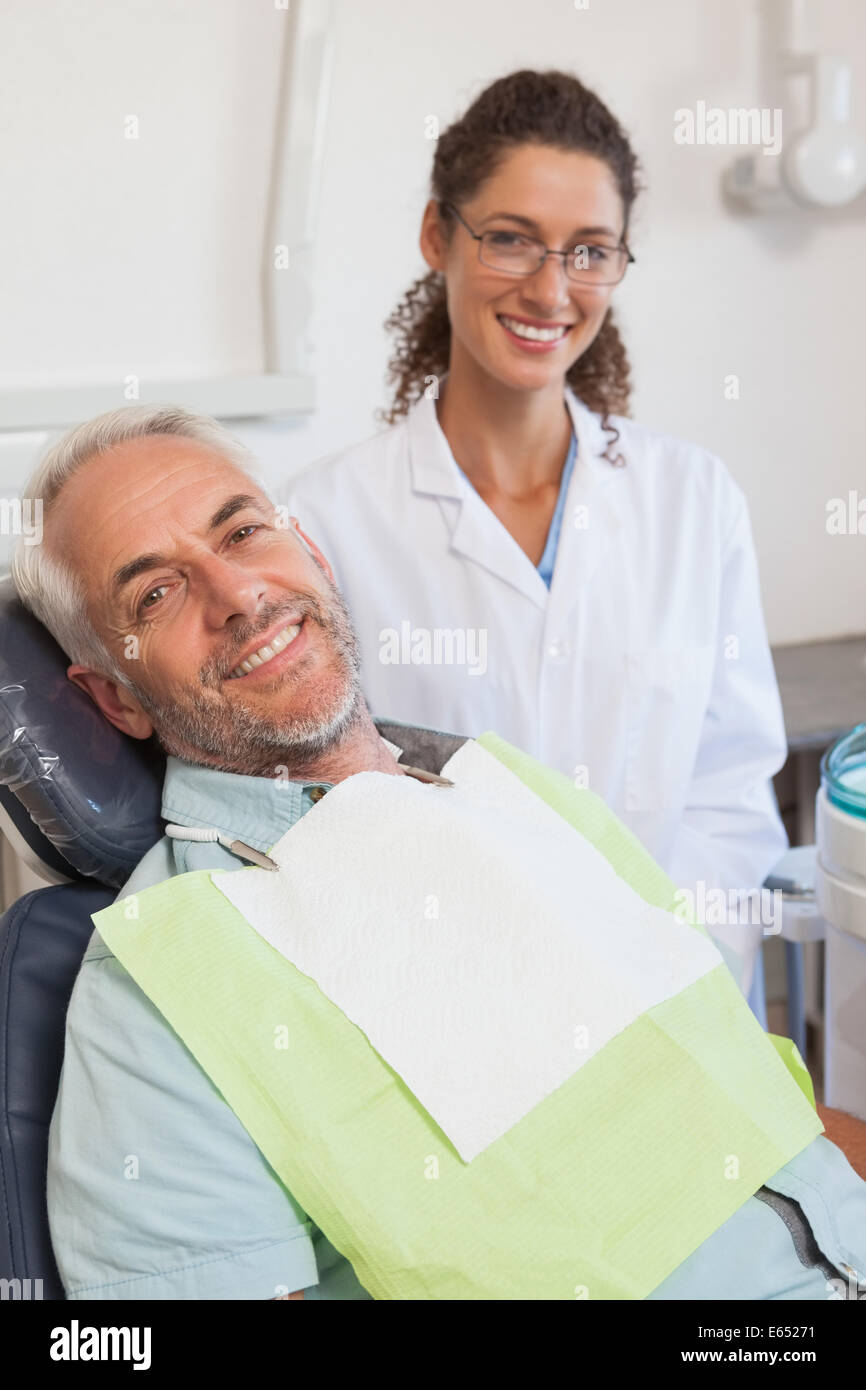 Patient and dentist smiling at camera Stock Photo - Alamy