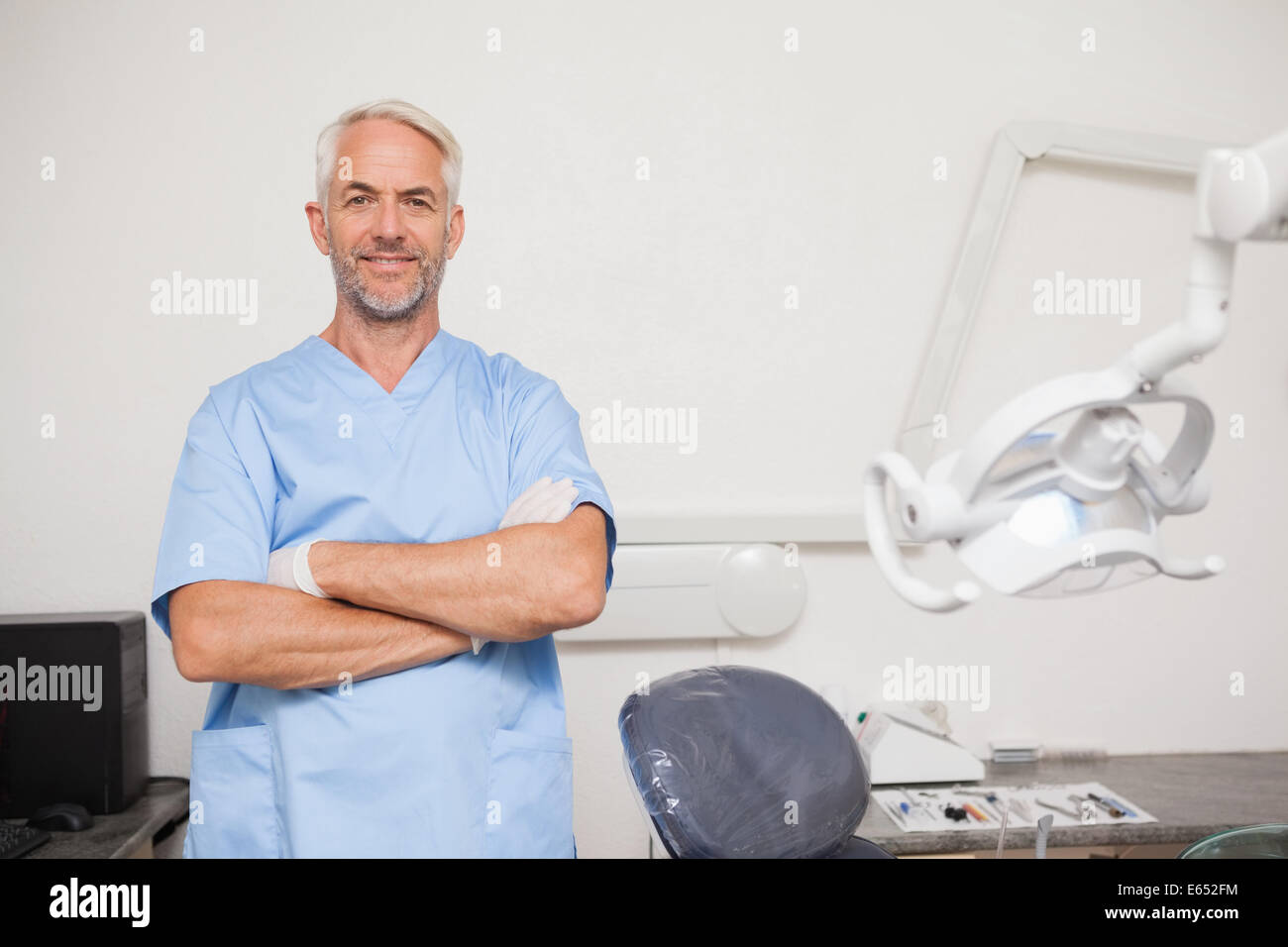 Dentist in blue scrubs smiling at camera Stock Photo - Alamy