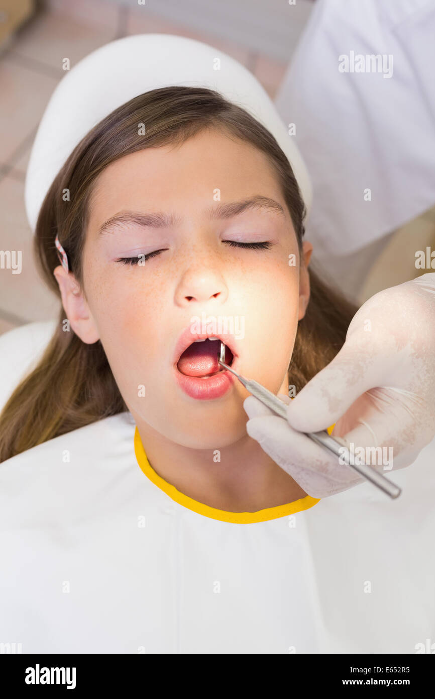 Pediatric dentist examining a patients teeth in the dentists chair ...