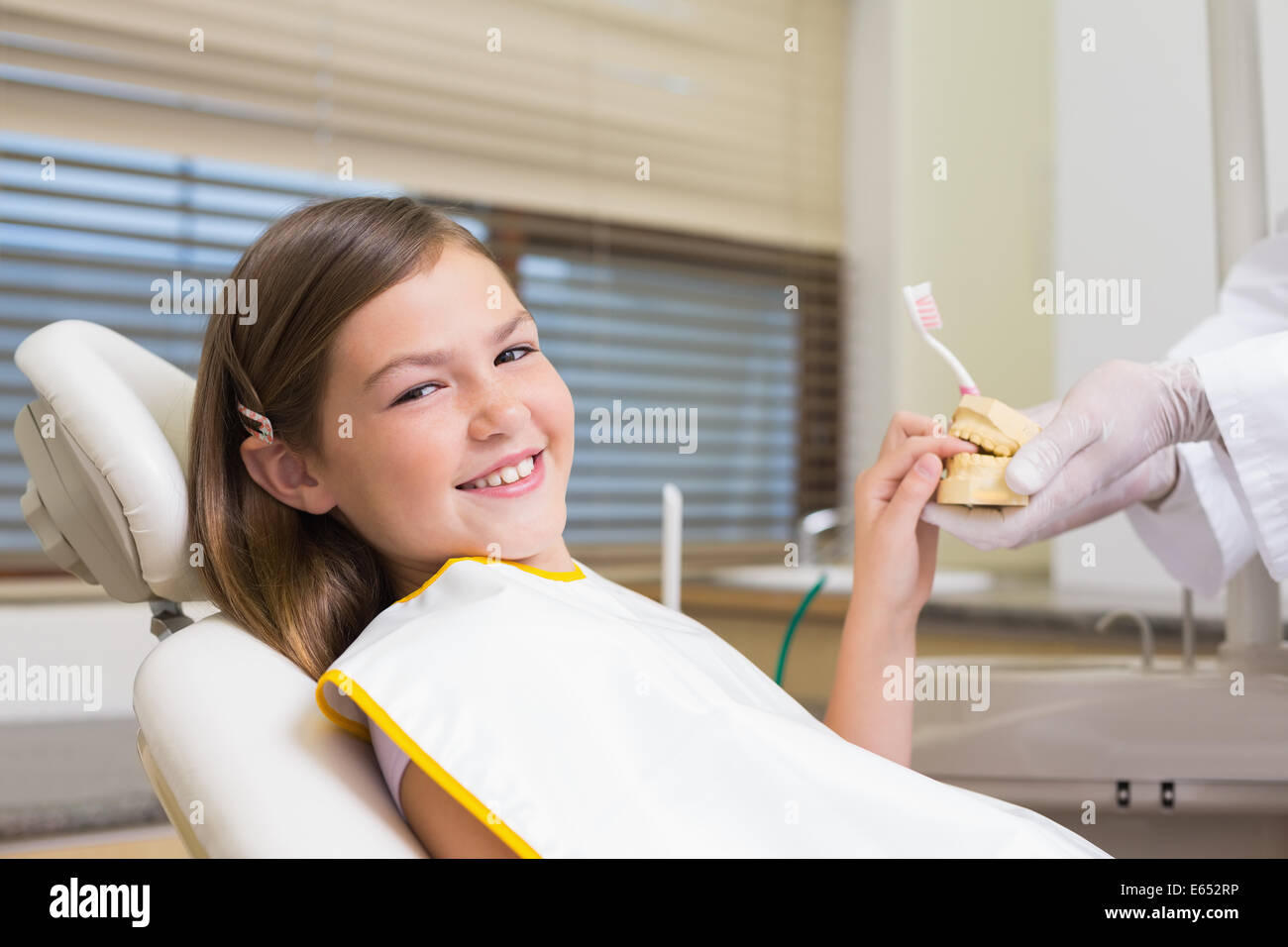 Pediatric dentist showing little girl teeth model Stock Photo - Alamy