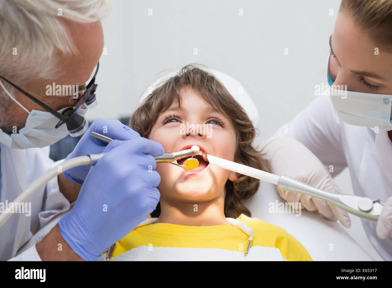 Pediatric dentist and assistant examining a little boys teeth Stock ...