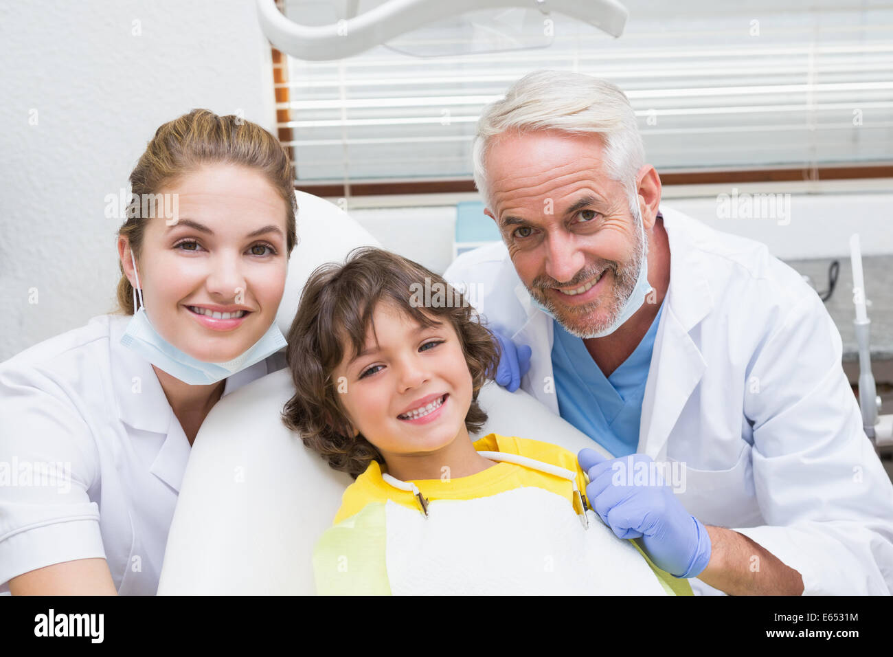 Pediatric dentist assistant and little boy all smiling at camera Stock ...
