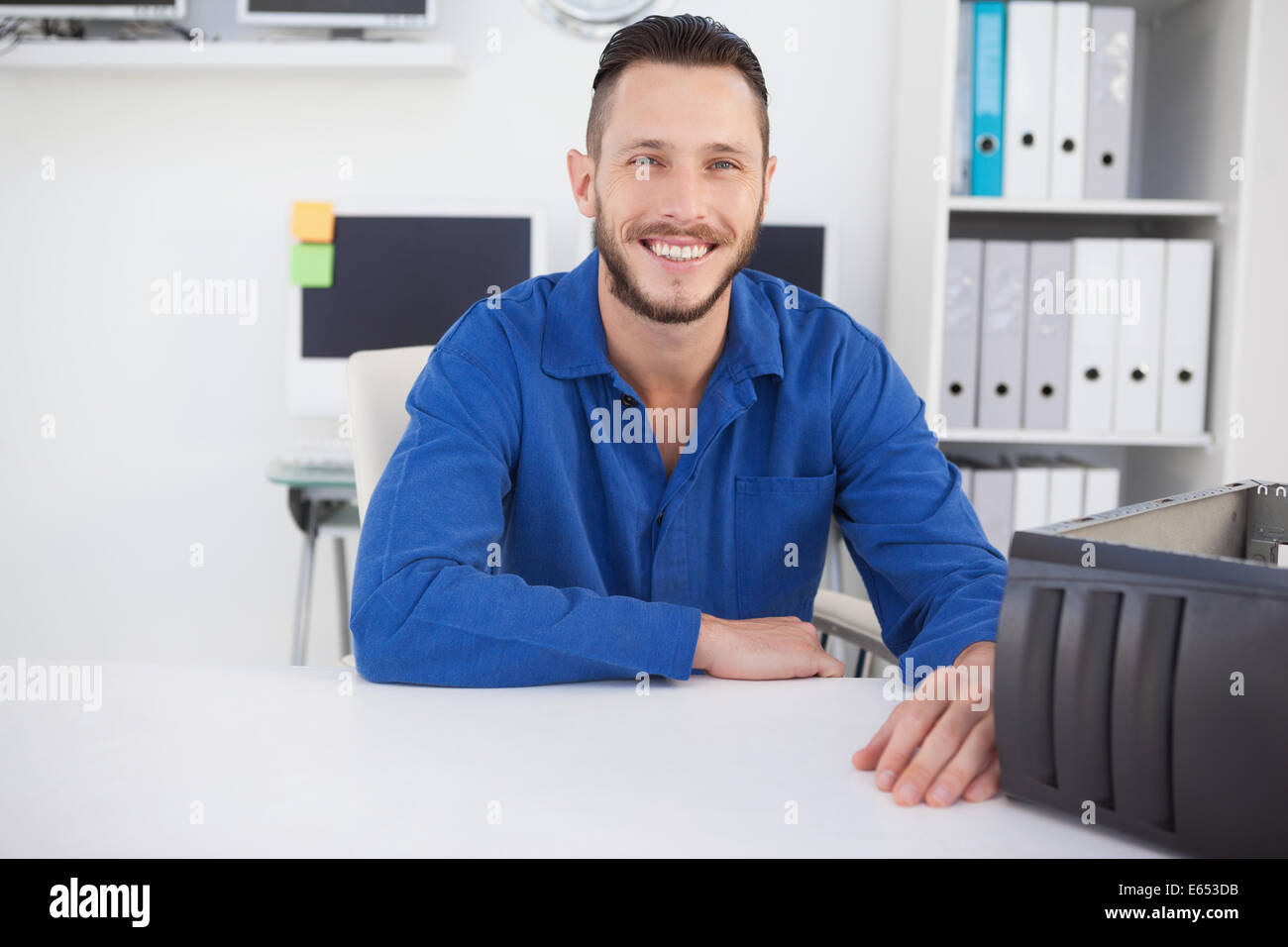 Computer engineer sitting at desk smiling at camera Stock Photo - Alamy