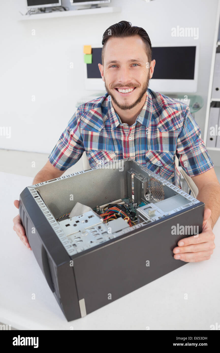 Computer engineer smiling at camera beside open console Stock Photo - Alamy