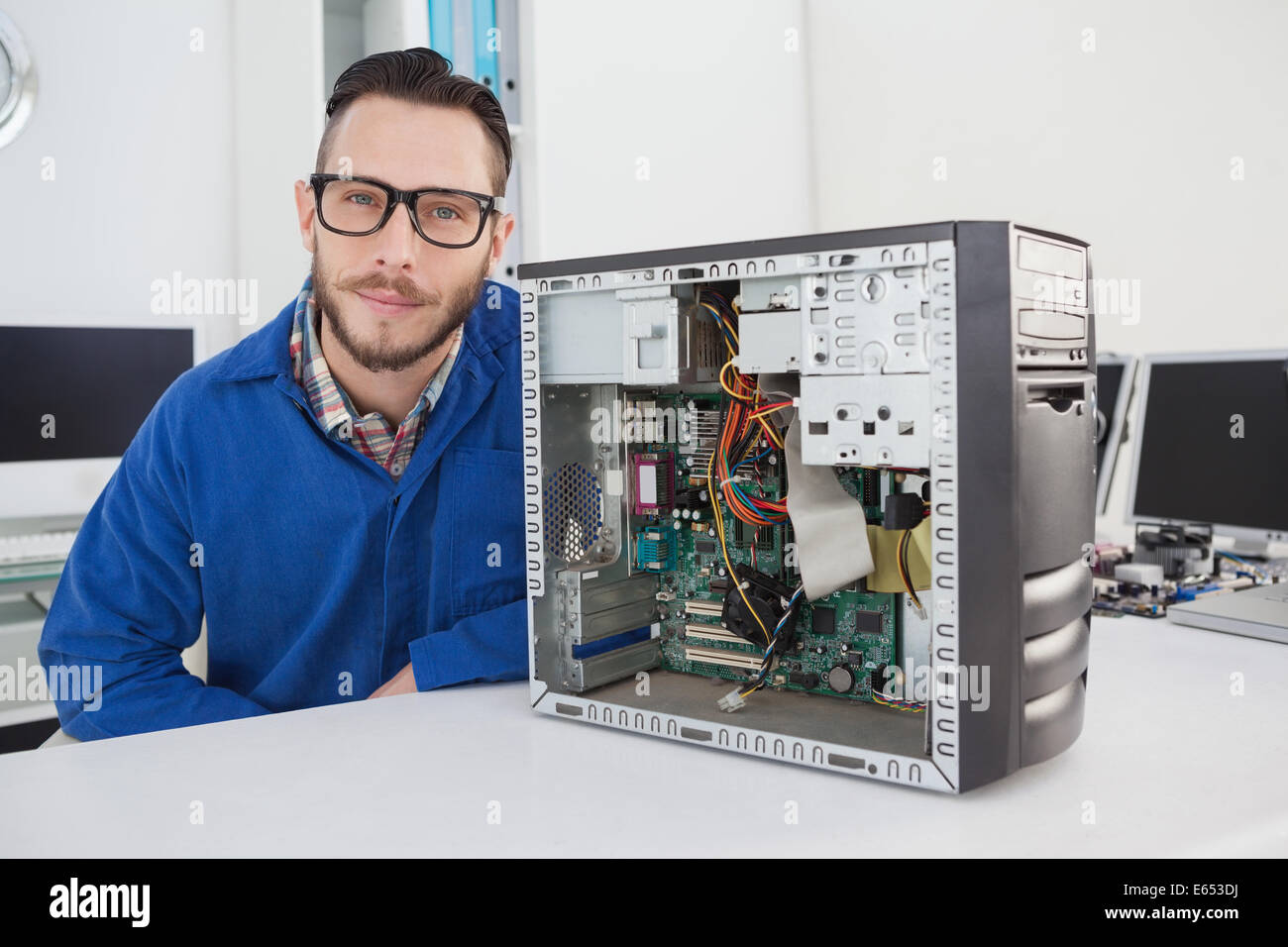 Computer engineer smiling at camera beside open console Stock Photo - Alamy