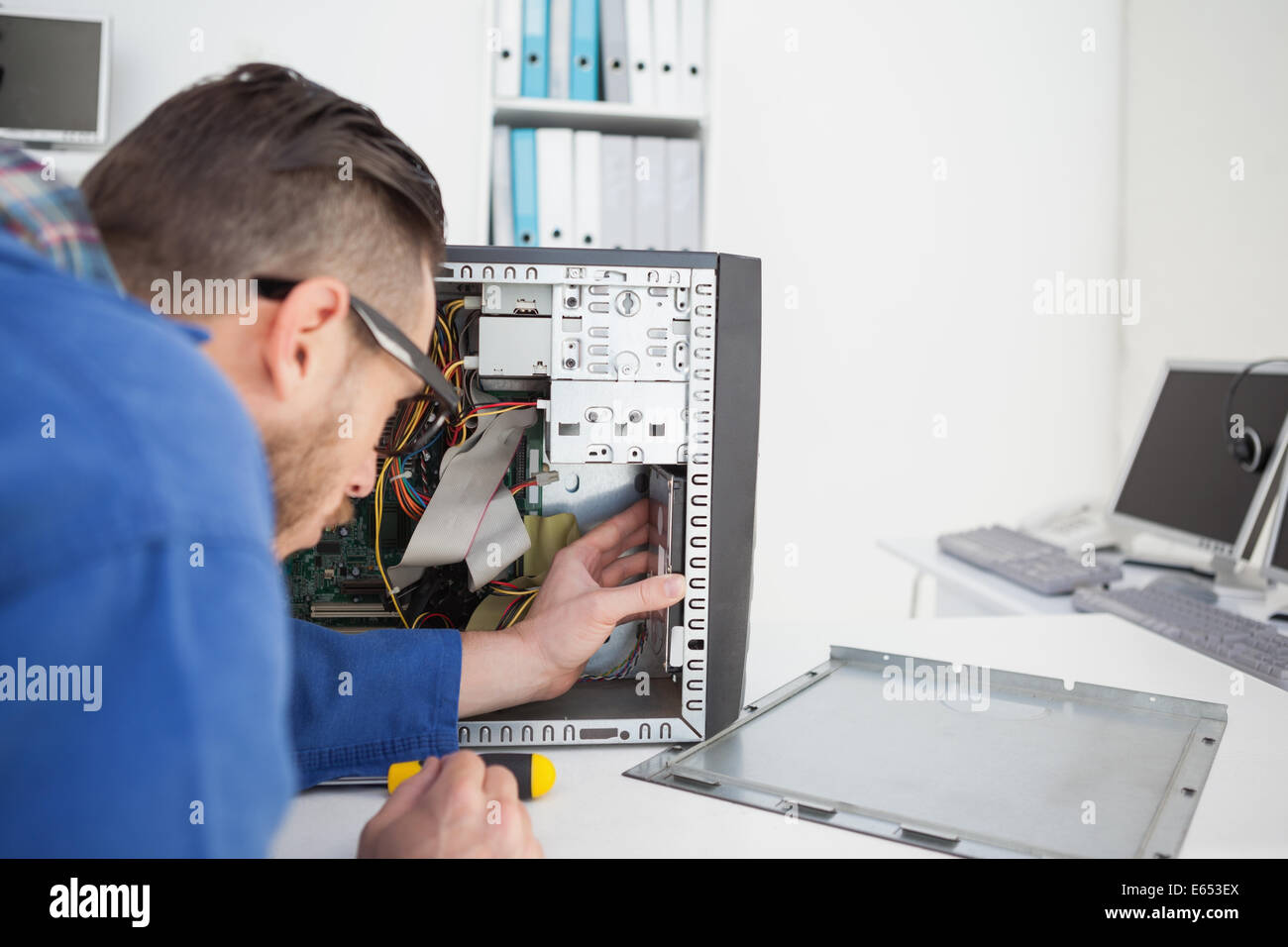 Computer engineer working on broken console with screwdriver Stock ...
