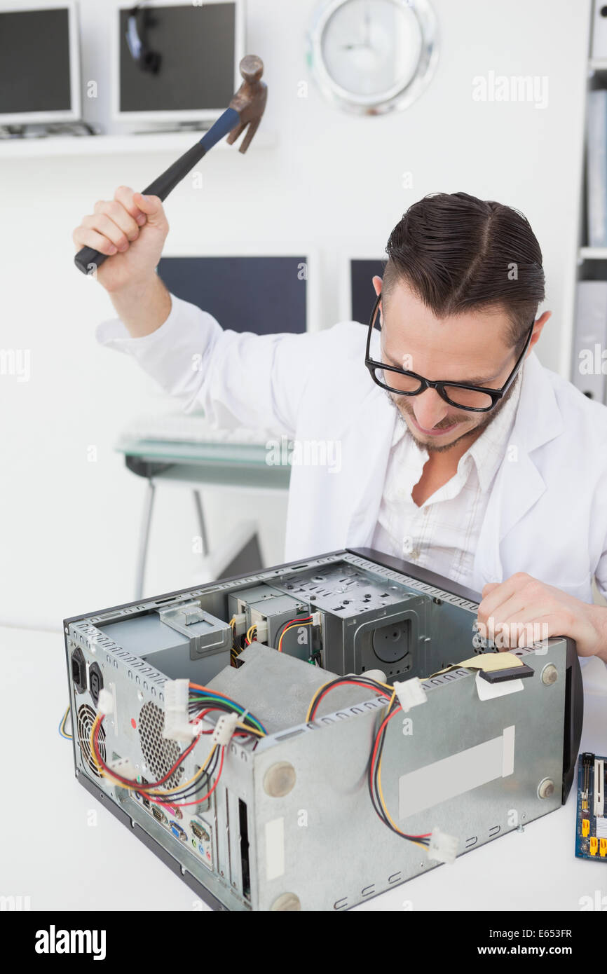Angry computer engineer holding hammer over console Stock Photo - Alamy