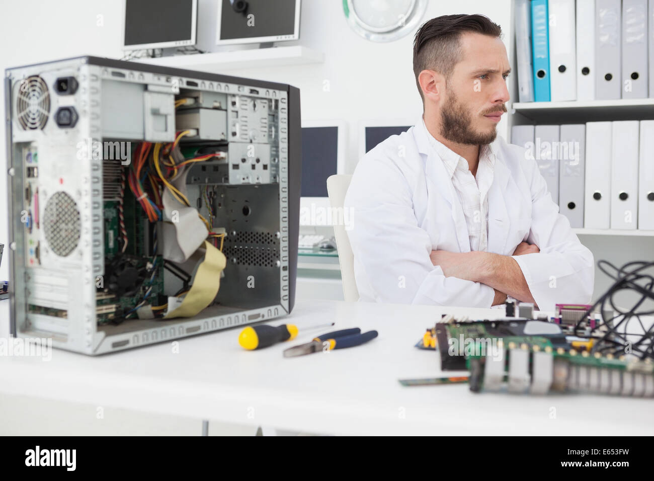 Computer engineer sitting with broken console Stock Photo - Alamy