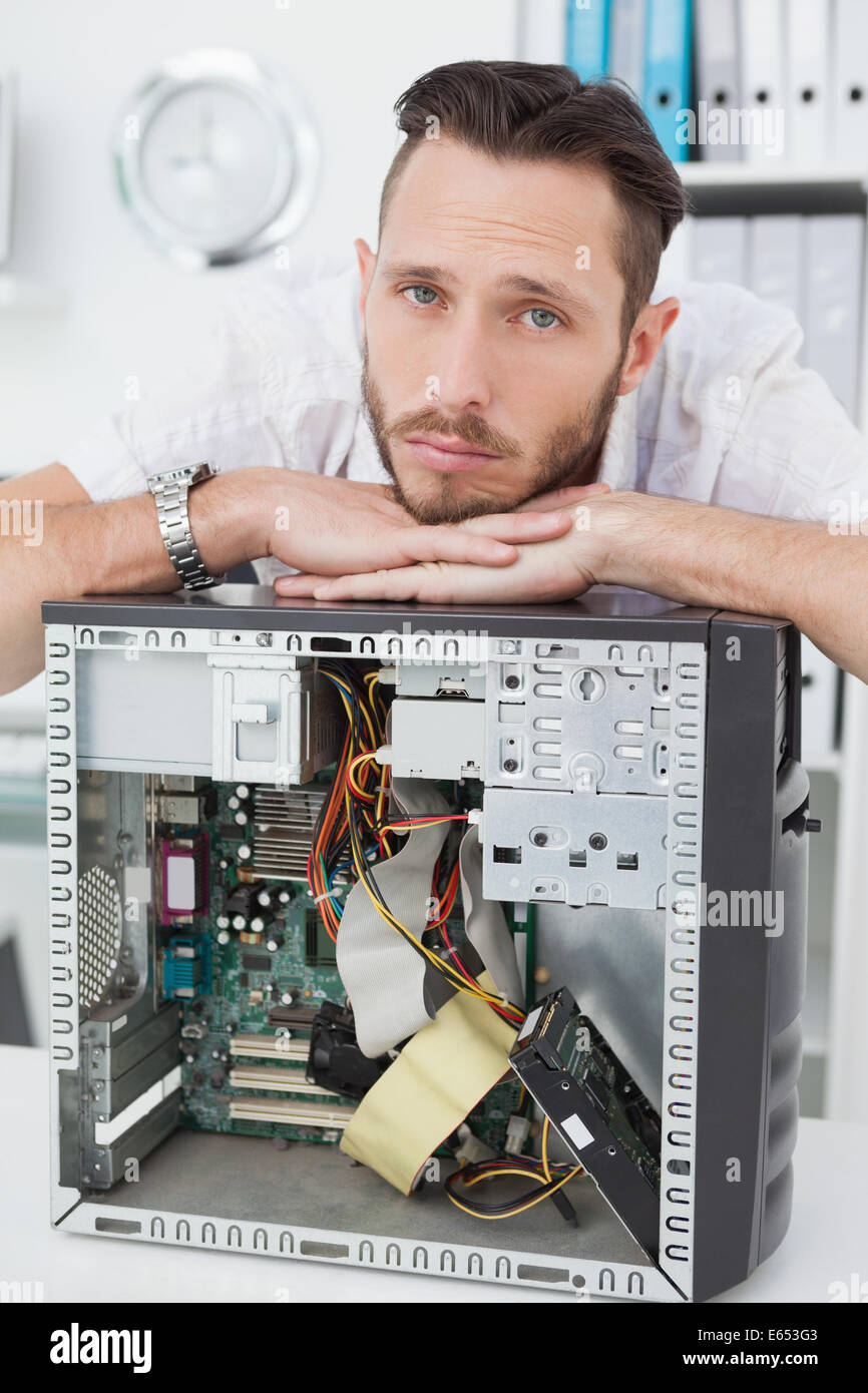 Sad computer engineer leaning on computer Stock Photo - Alamy