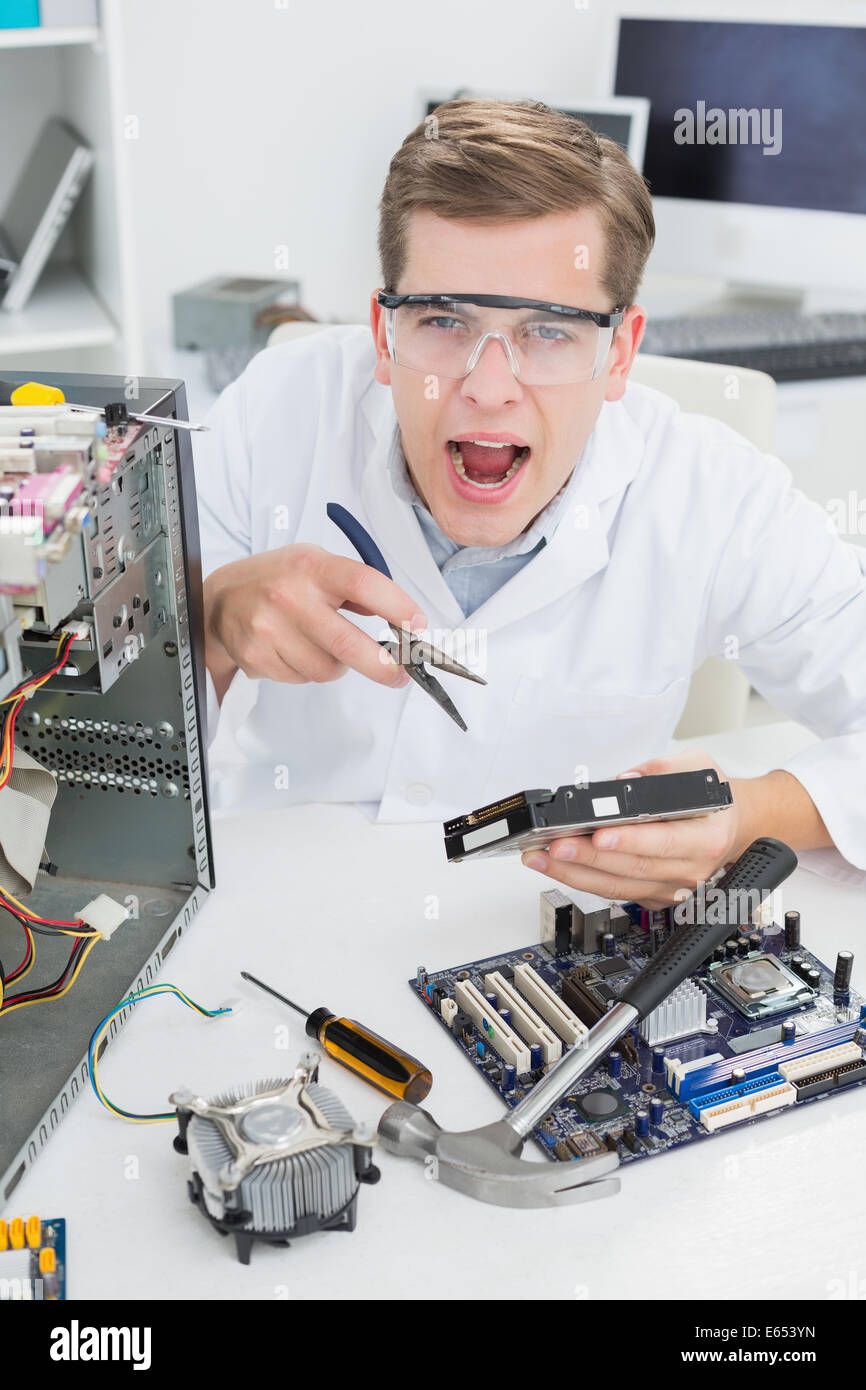 Angry computer engineer working on broken device Stock Photo - Alamy