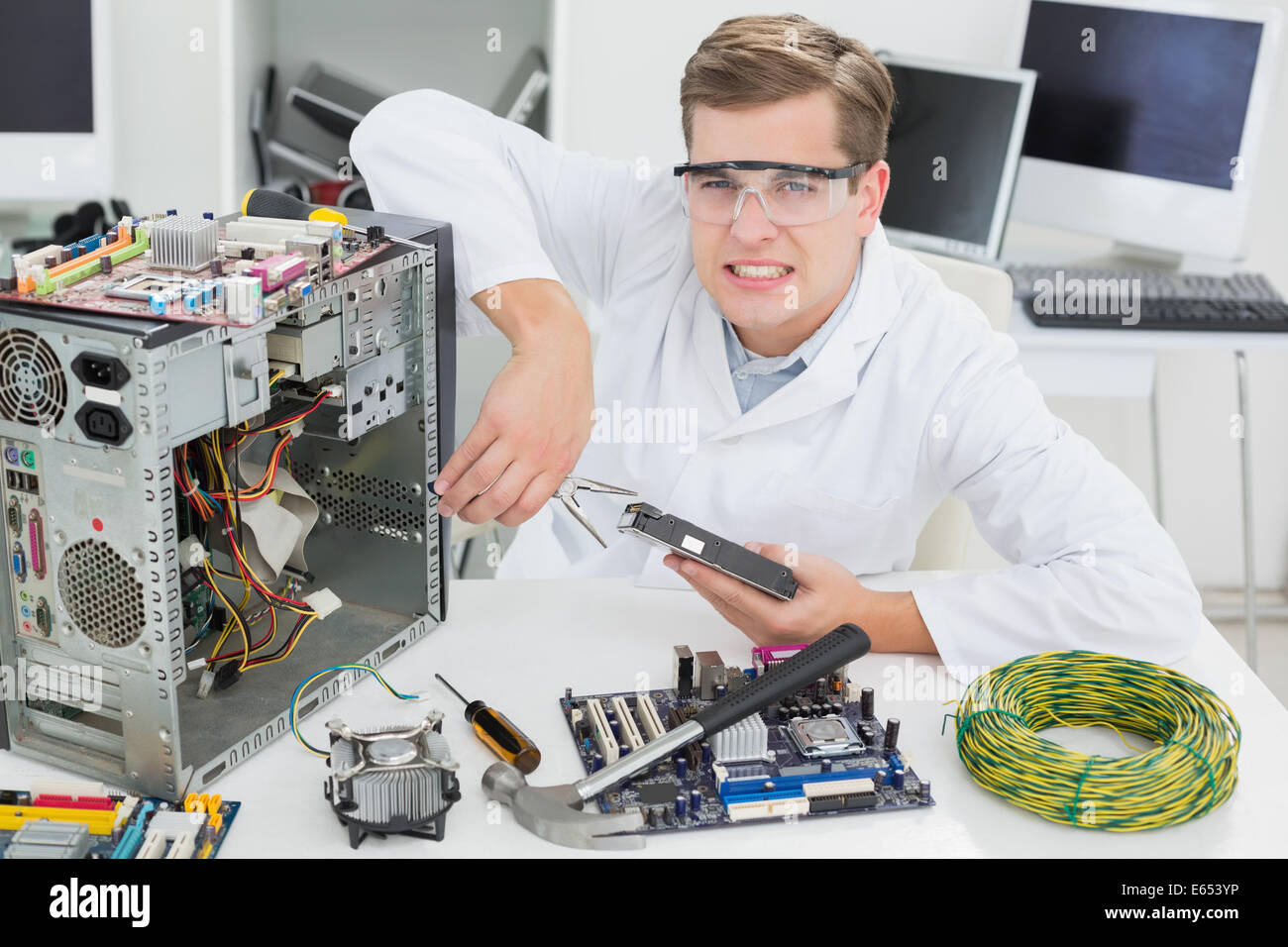 Angry computer engineer working on broken device Stock Photo - Alamy