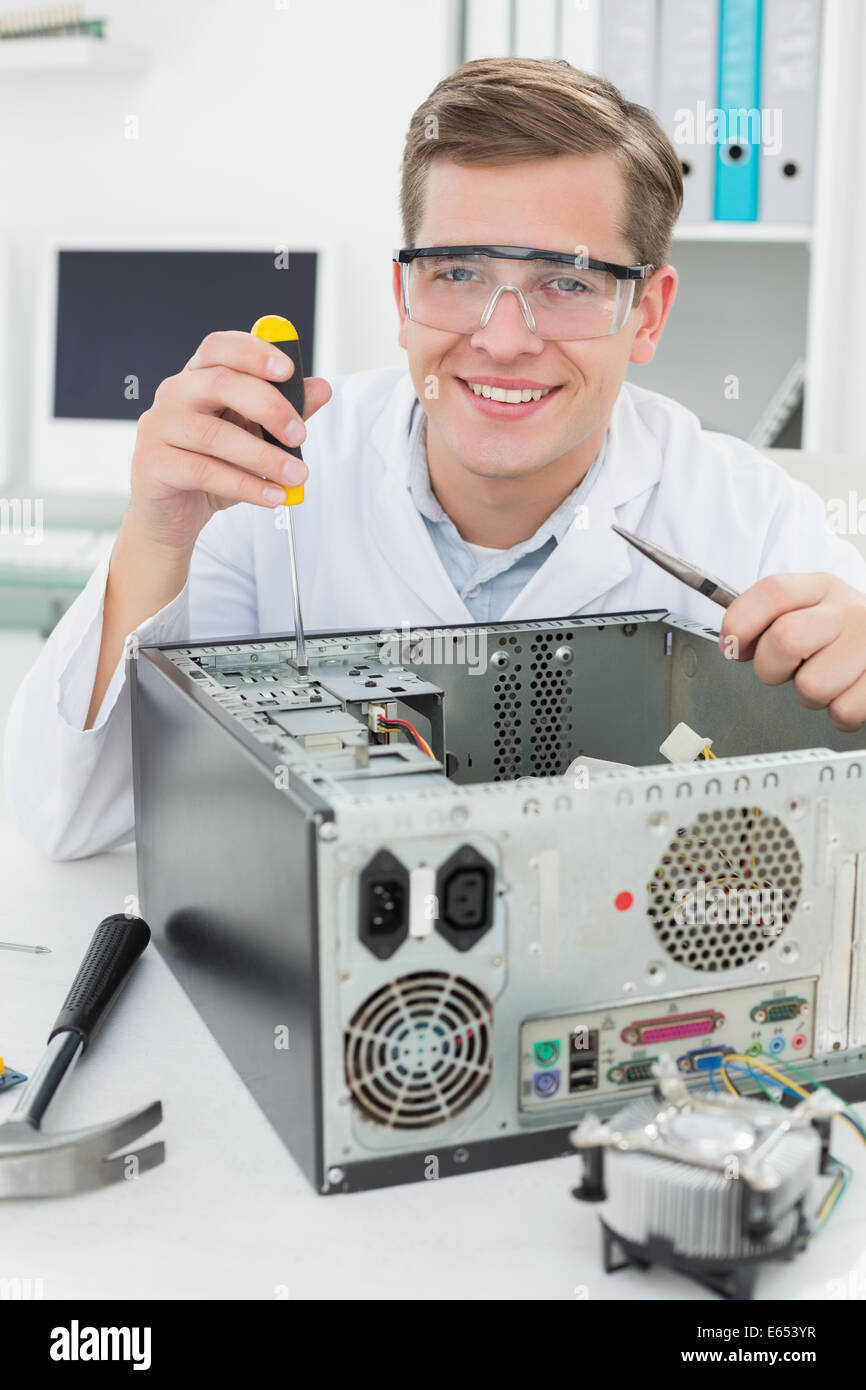 Happy computer engineer working on broken device Stock Photo - Alamy