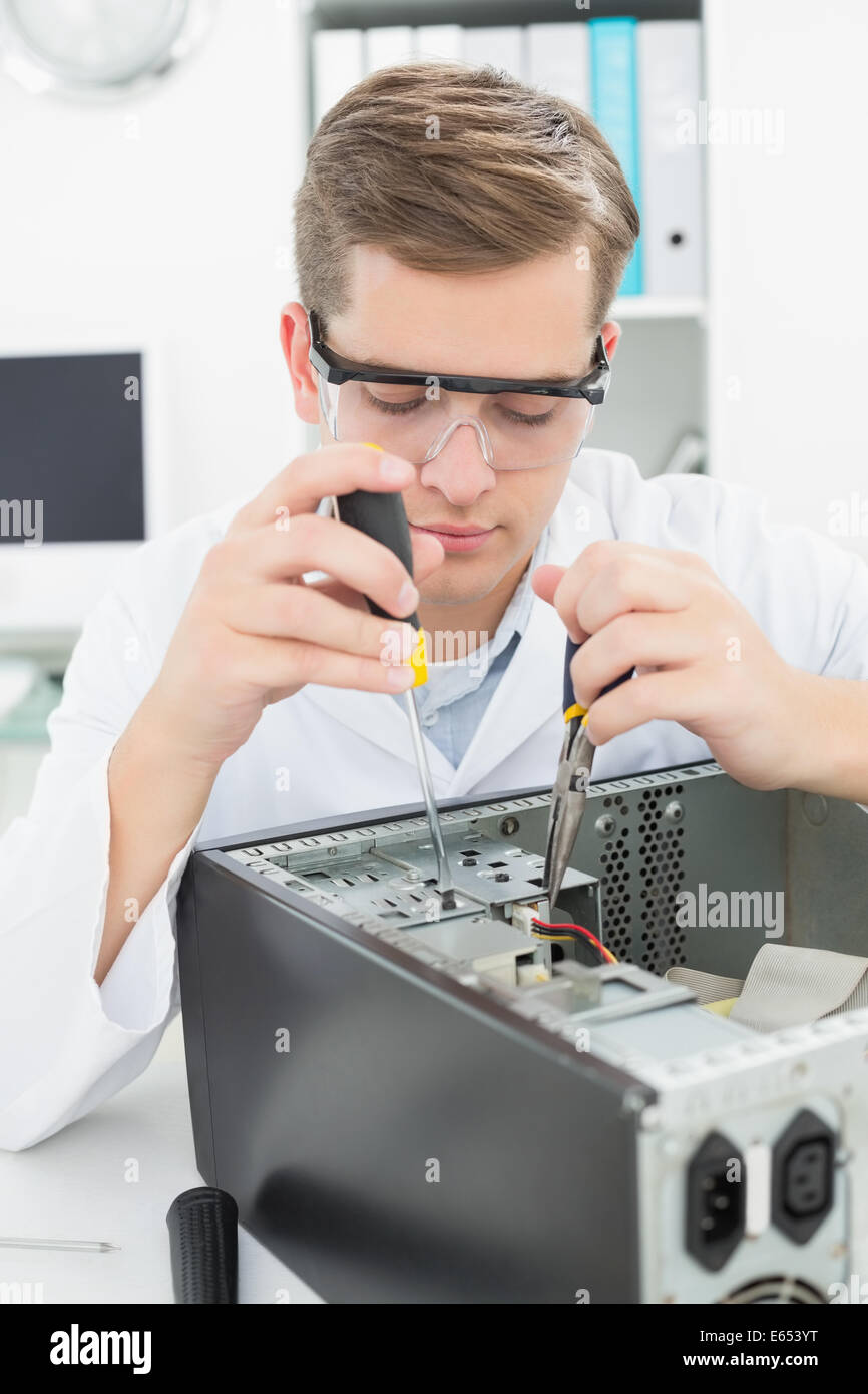 Computer engineer working on broken device with screwdriver Stock Photo ...