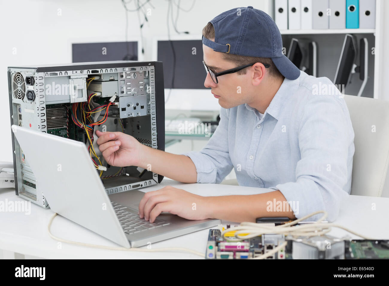 Computer engineer working on broken console with laptop Stock Photo - Alamy