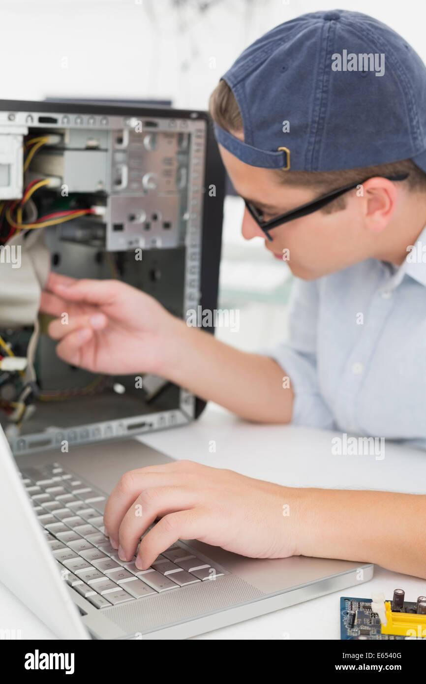 Computer engineer working on broken console with laptop Stock Photo - Alamy