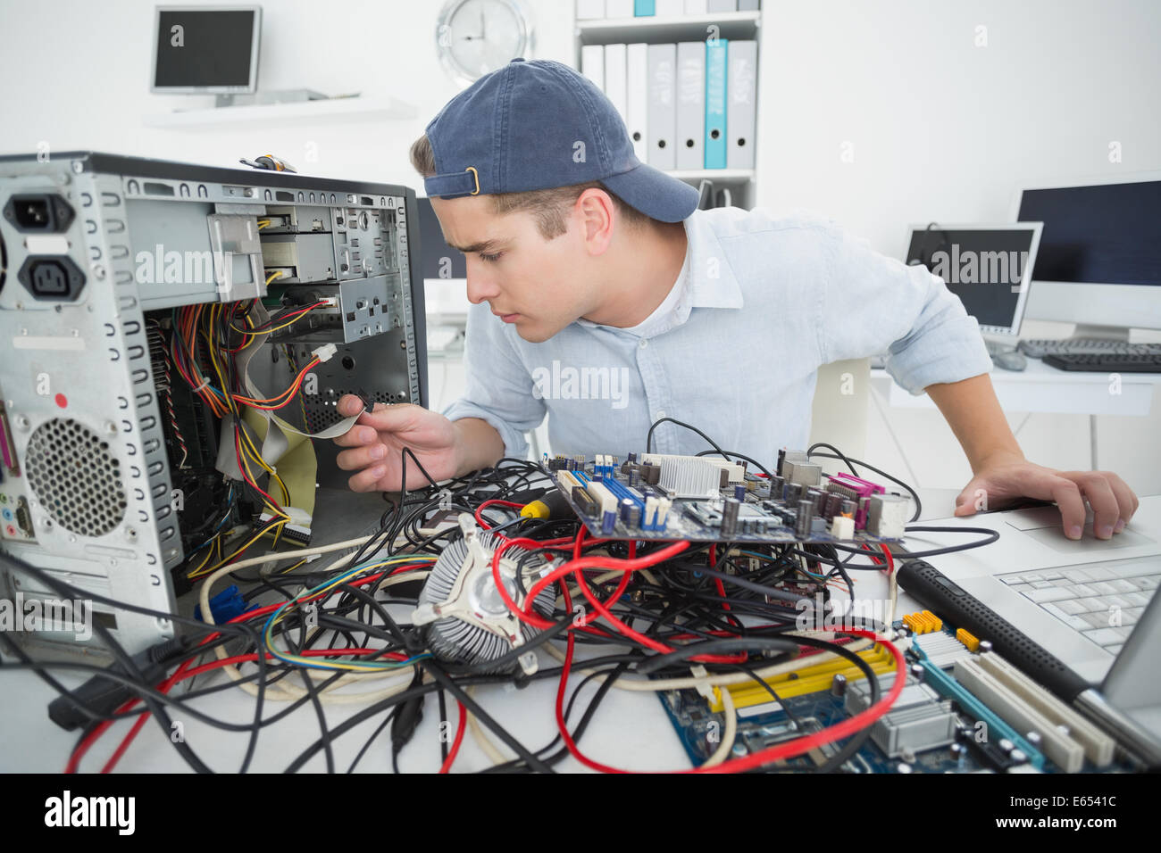 Computer engineer working on broken console with laptop Stock Photo - Alamy