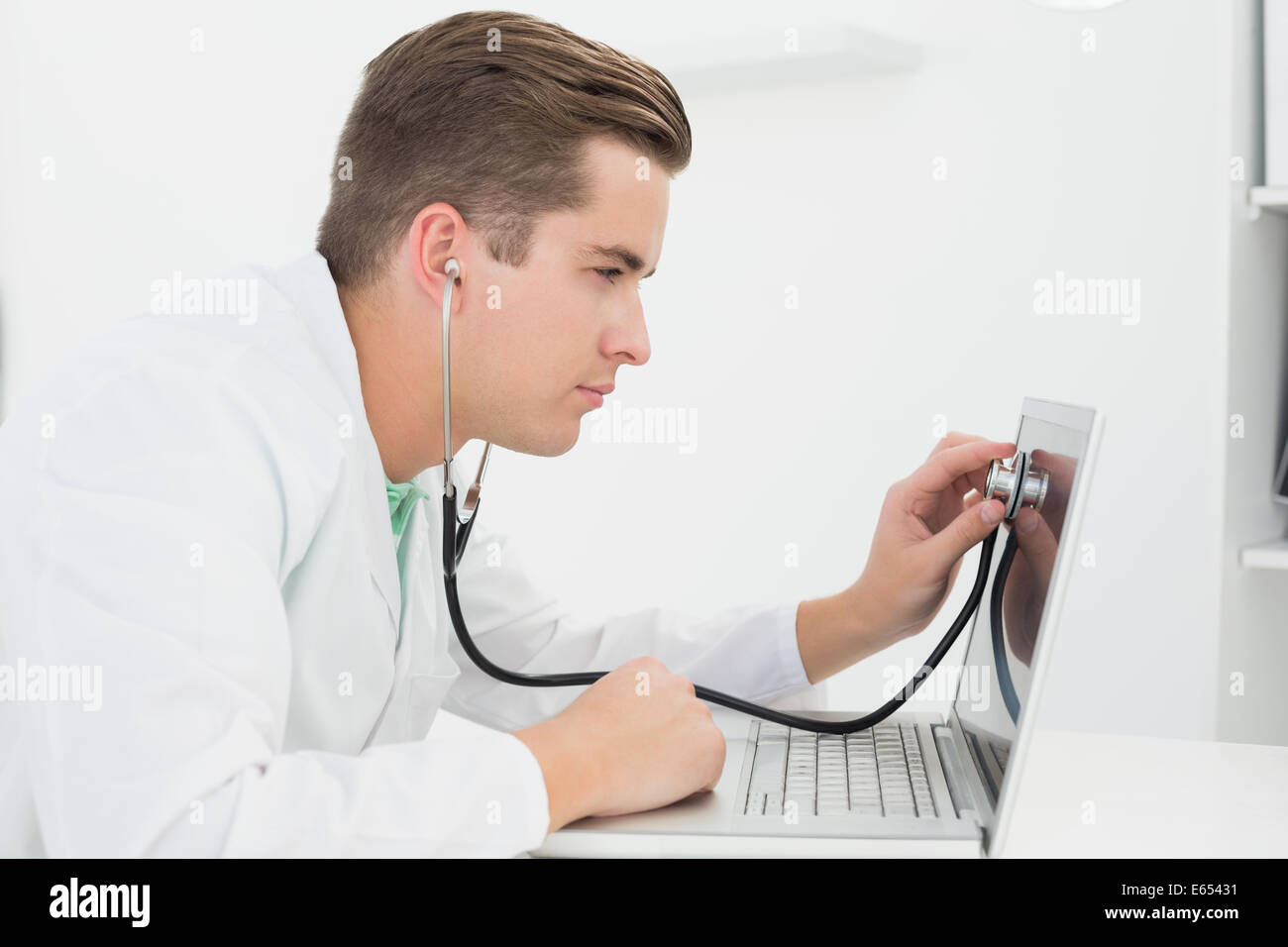 Technician listening to laptop with stethoscope Stock Photo - Alamy