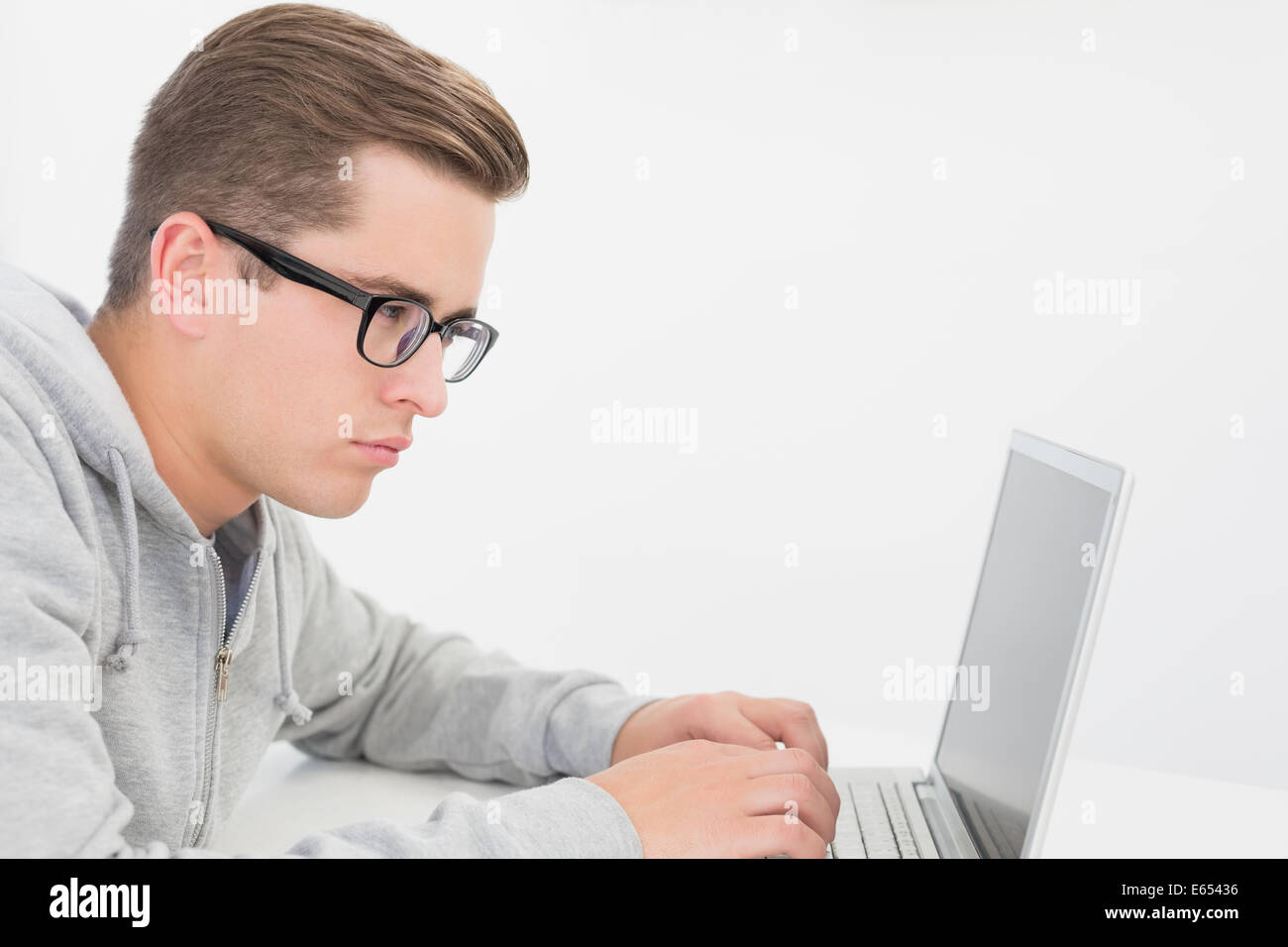 Casual man working at desk with laptop Stock Photo - Alamy