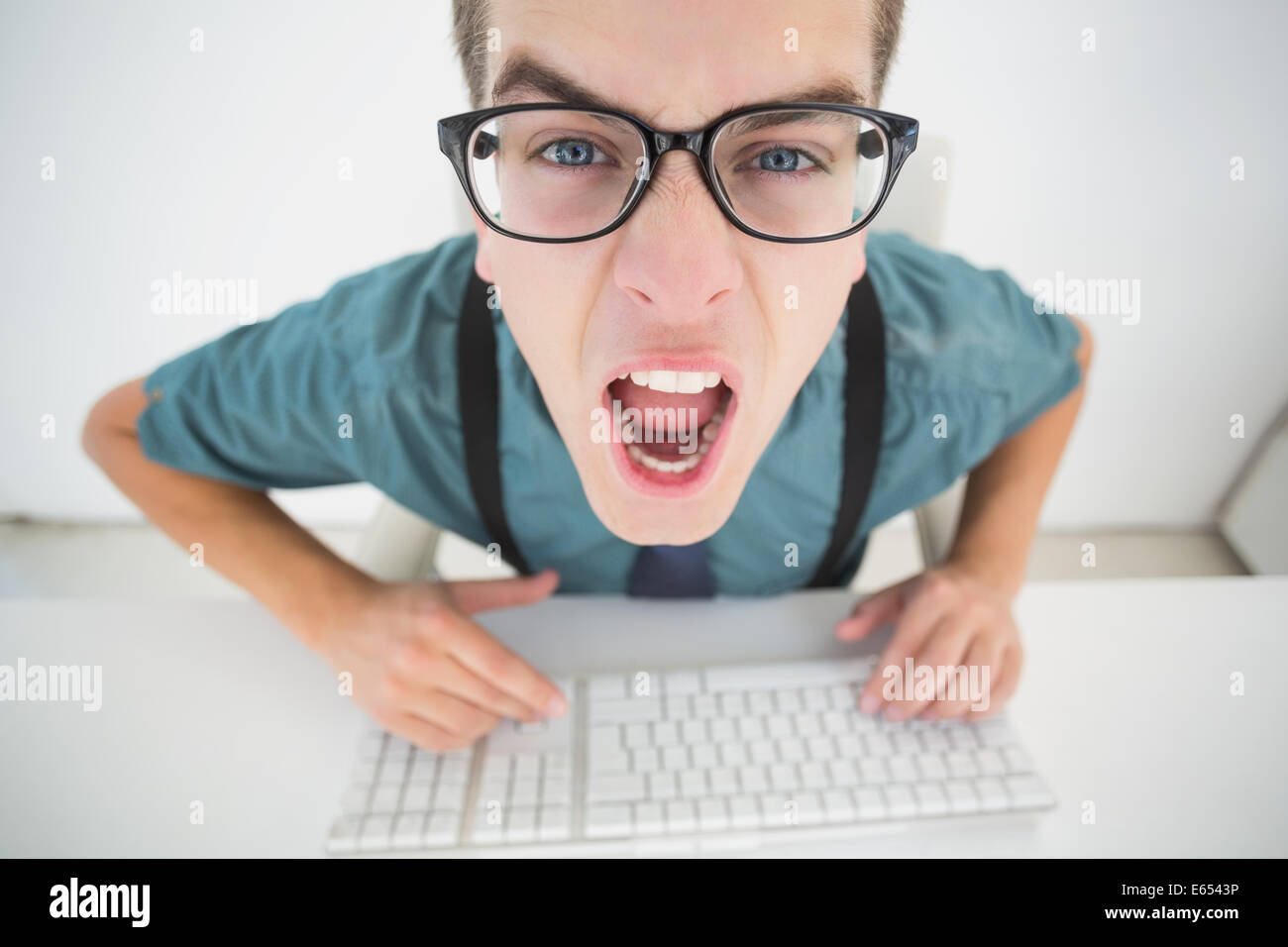 Casual angry businessman typing at his desk Stock Photo - Alamy