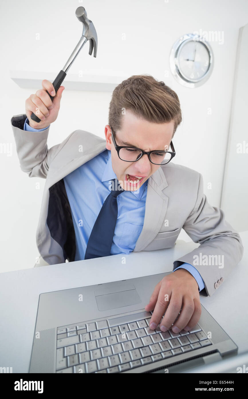 Angry businessman holding hammer over laptop Stock Photo - Alamy