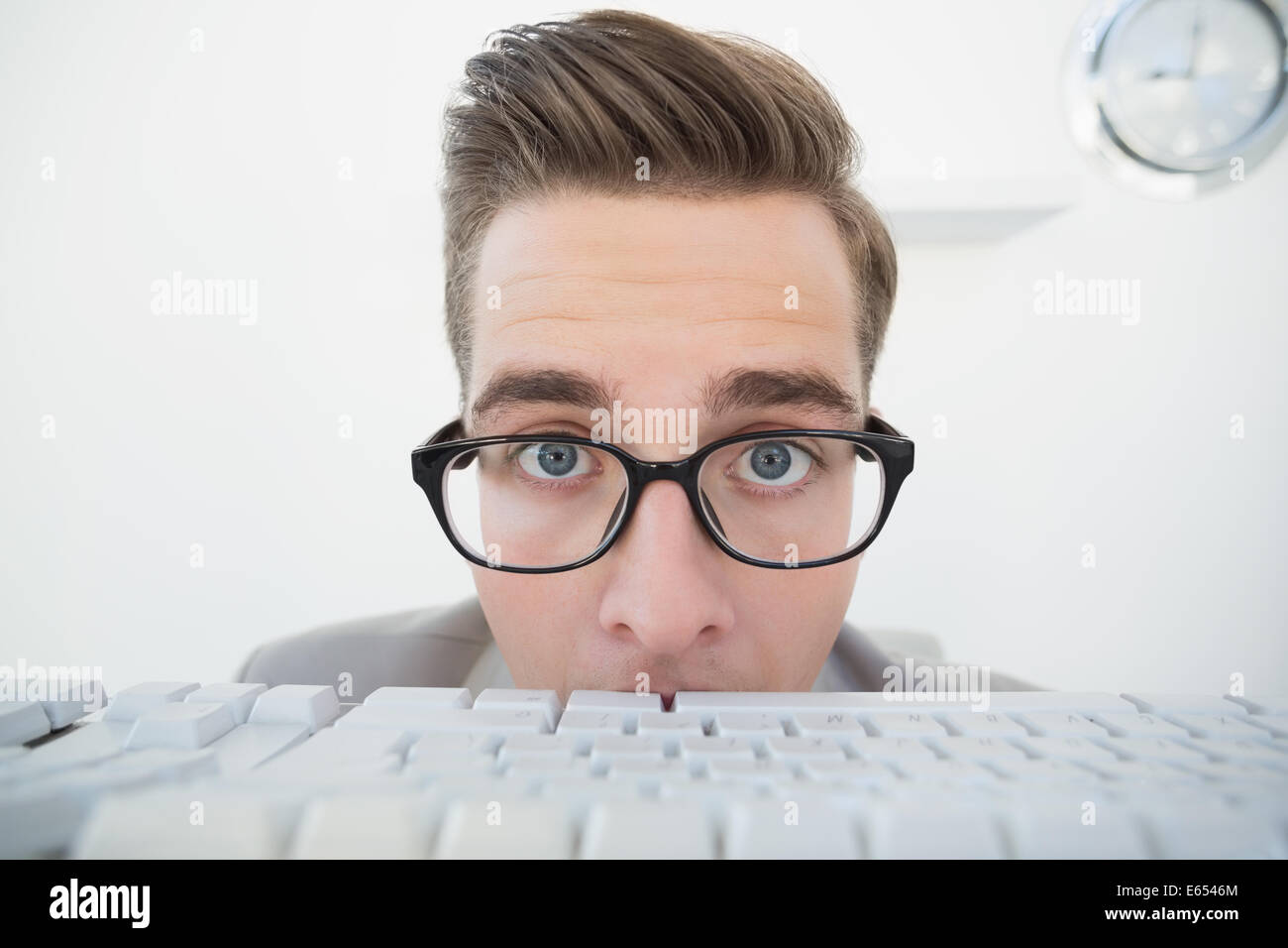 Nerdy businessman looking at keyboard Stock Photo - Alamy