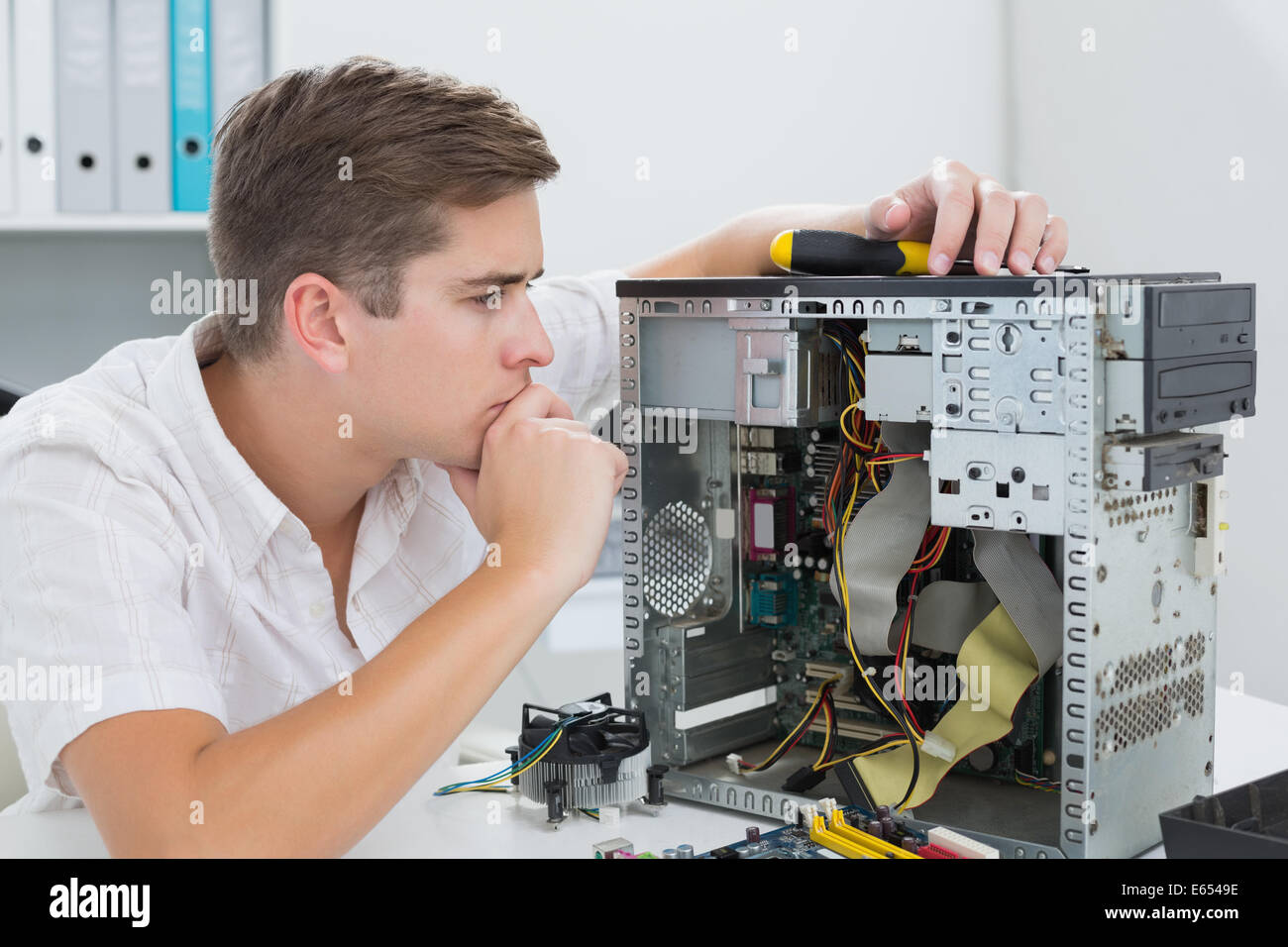 Young technician working on broken computer Stock Photo - Alamy