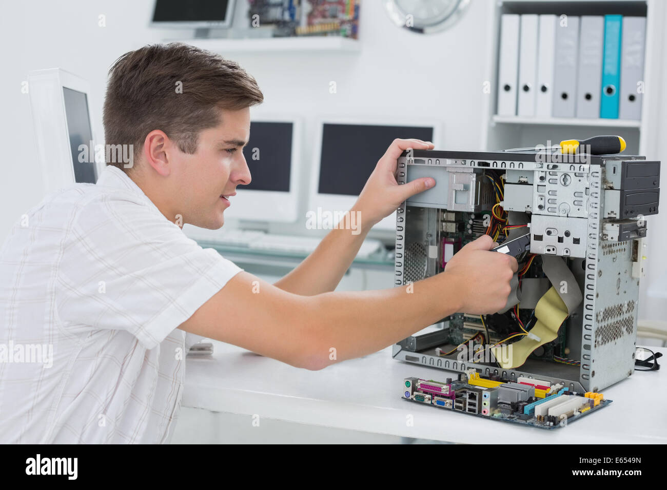 Young technician working on broken computer Stock Photo - Alamy