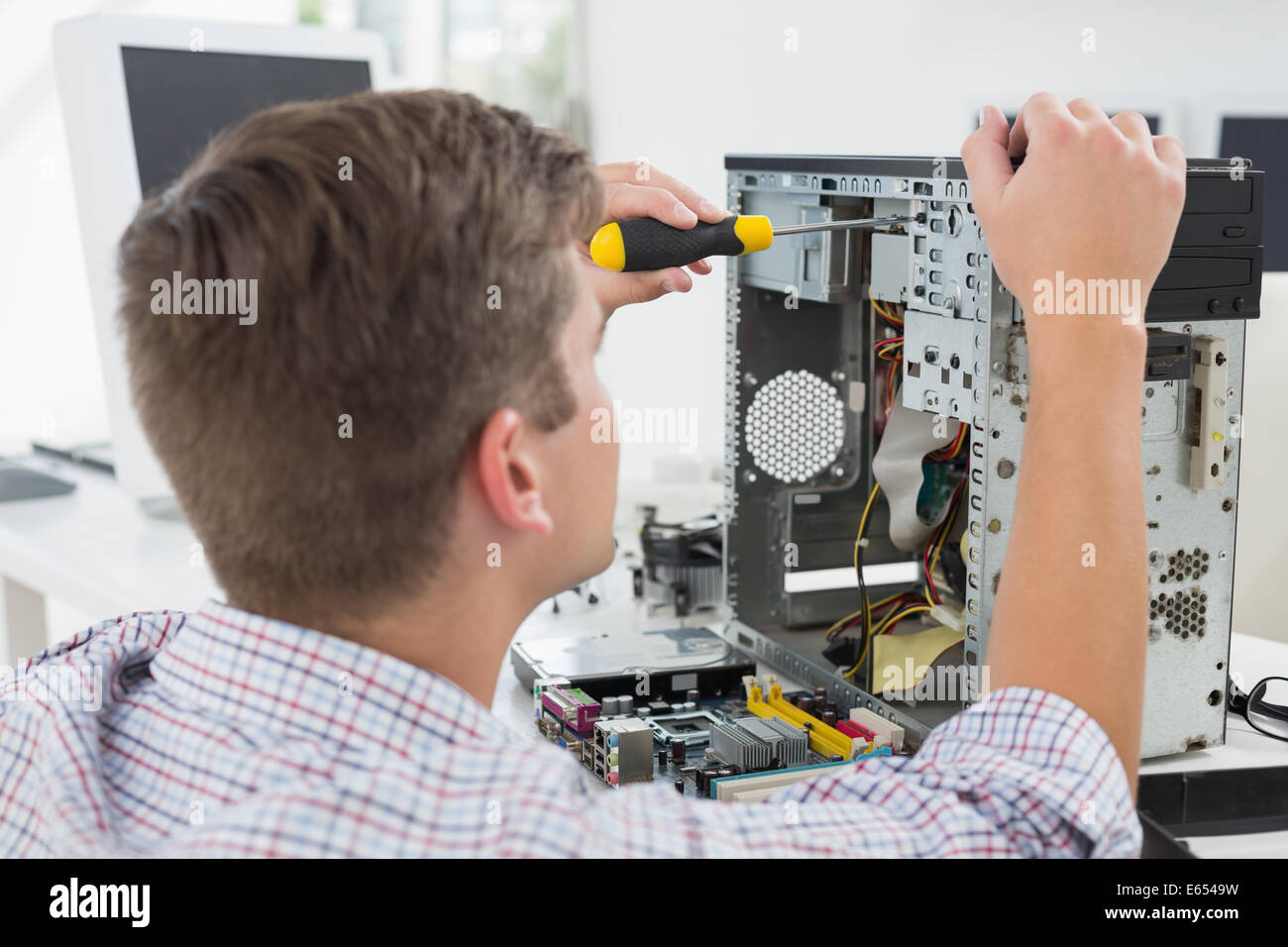 Young technician working on broken computer Stock Photo - Alamy