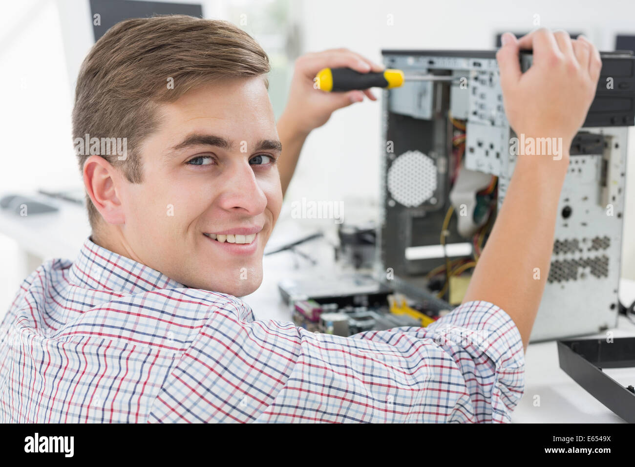 Young technician working on broken computer Stock Photo - Alamy