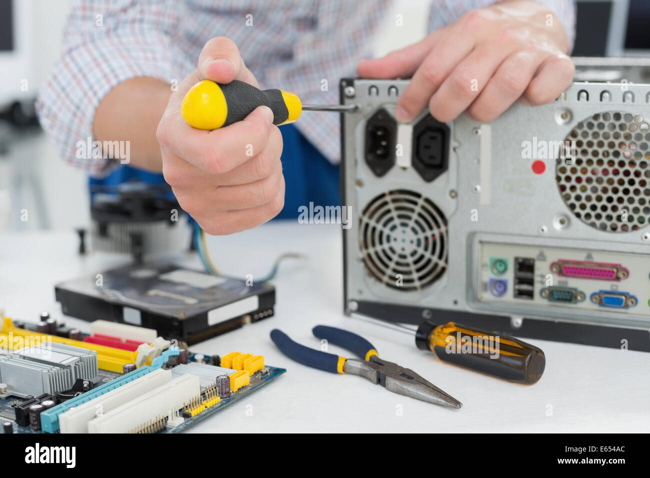 Young technician working on broken computer Stock Photo - Alamy