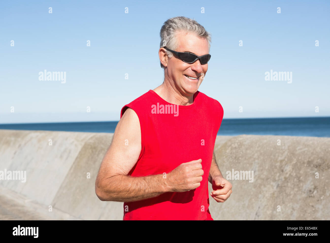 Active senior man jogging on the pier Stock Photo - Alamy