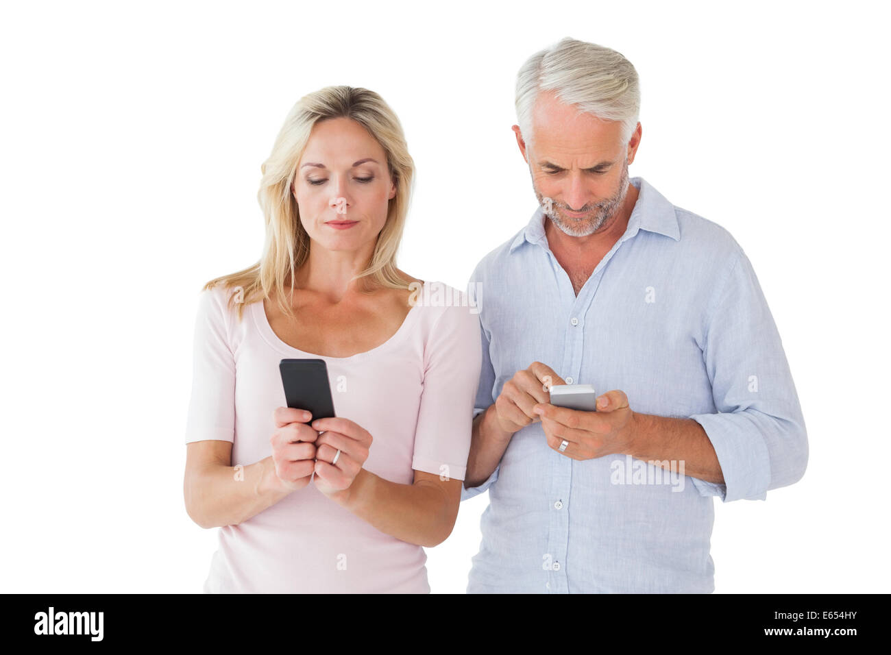 Happy couple texting on their smartphones Stock Photo - Alamy