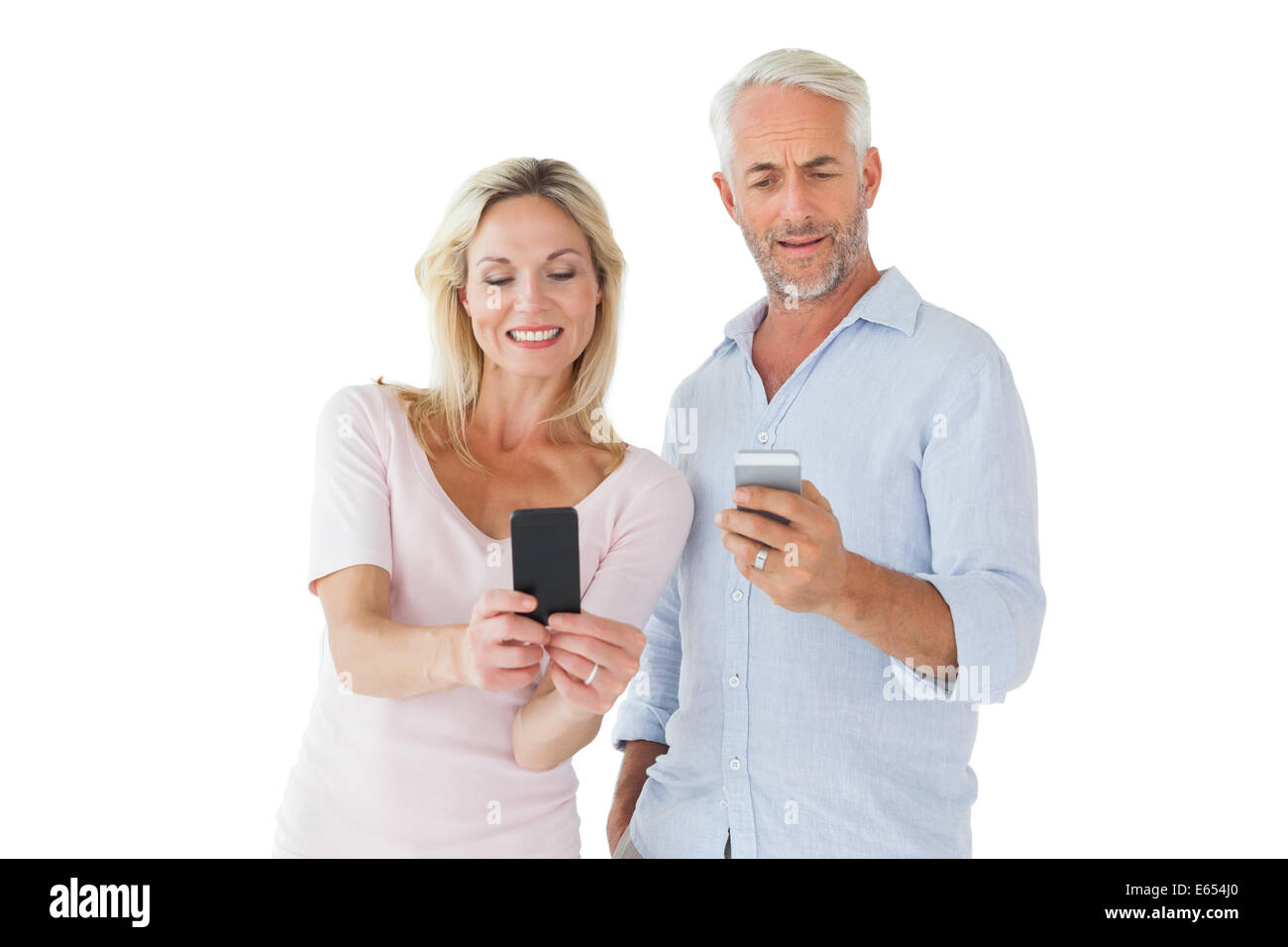 Happy couple texting on their smartphones Stock Photo - Alamy
