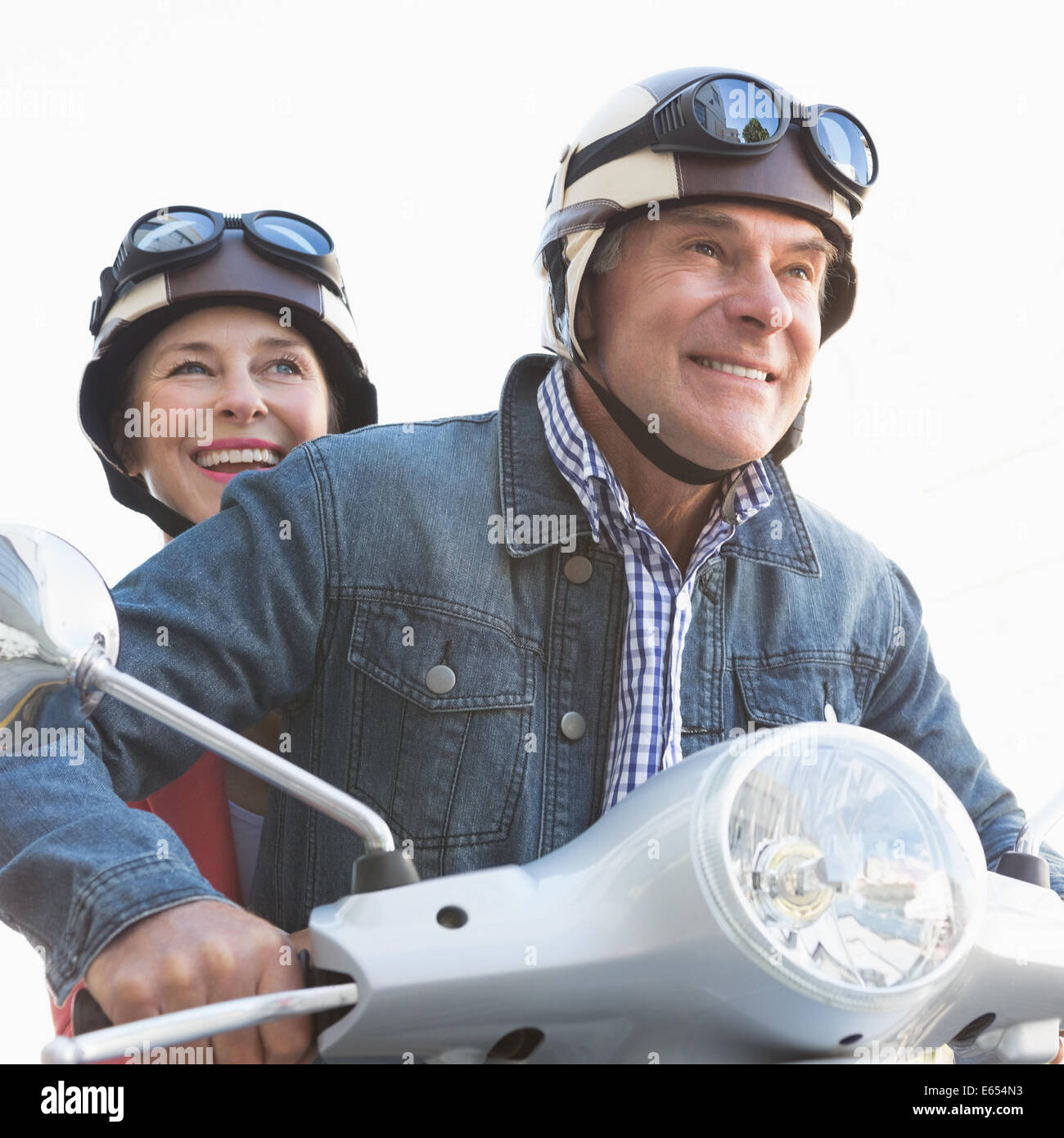 Happy senior couple riding a moped Stock Photo - Alamy