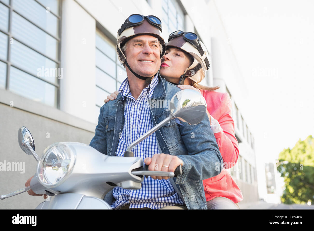Happy senior couple riding a moped Stock Photo - Alamy